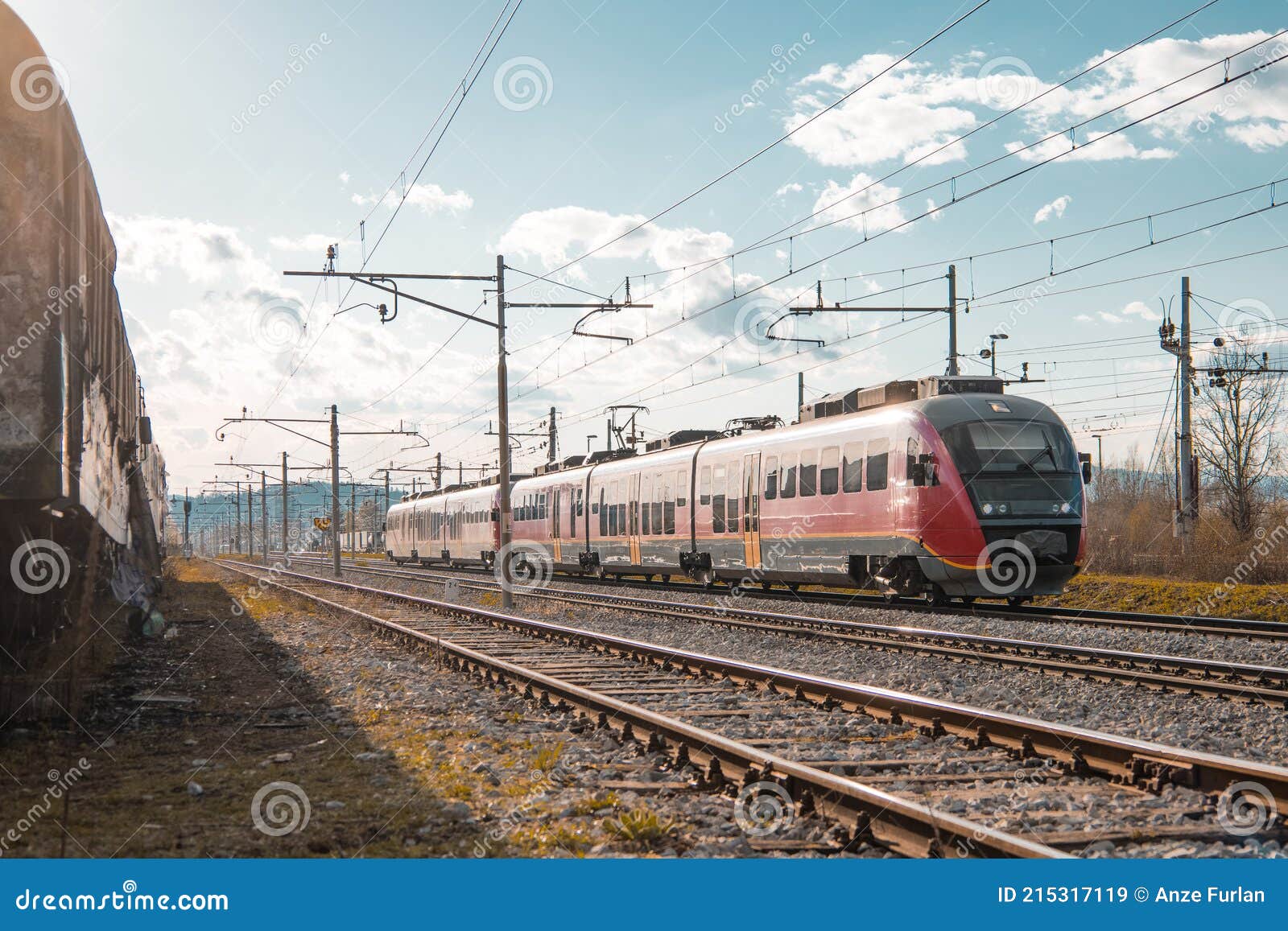 Red Modern Passenger Train Rushing through Industrial District on a ...