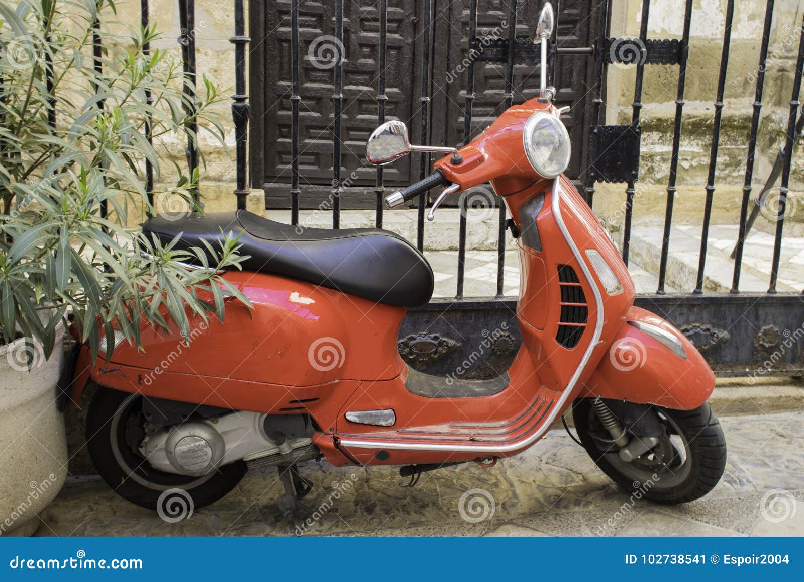 The Moped Stands Motionless in Front of the Iron Gate. Stock Image ...