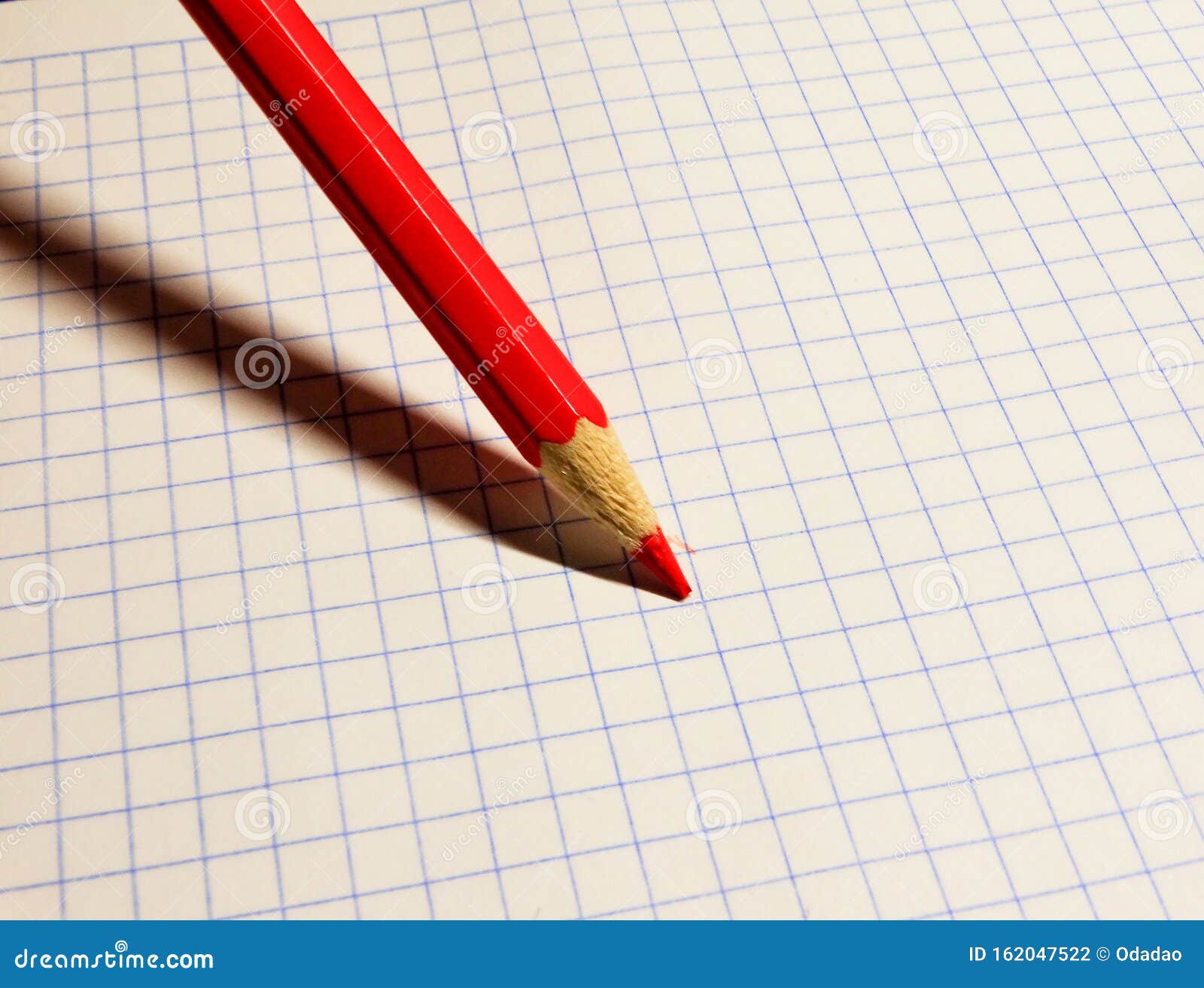 A Red Pencil on a Checkered Notebook Sheet Stock Photo - Image of ...