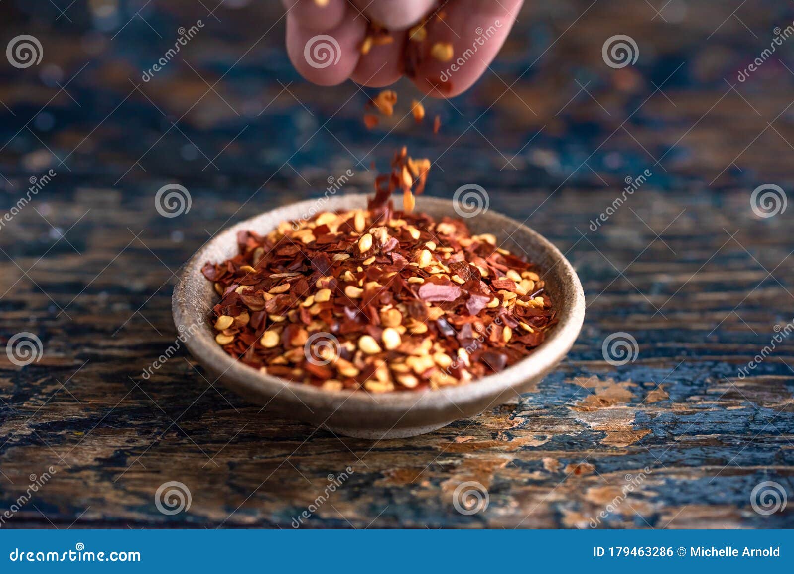 Red Pepper Flakes Sprinkled into a Bowl Stock Photo - Image of ...