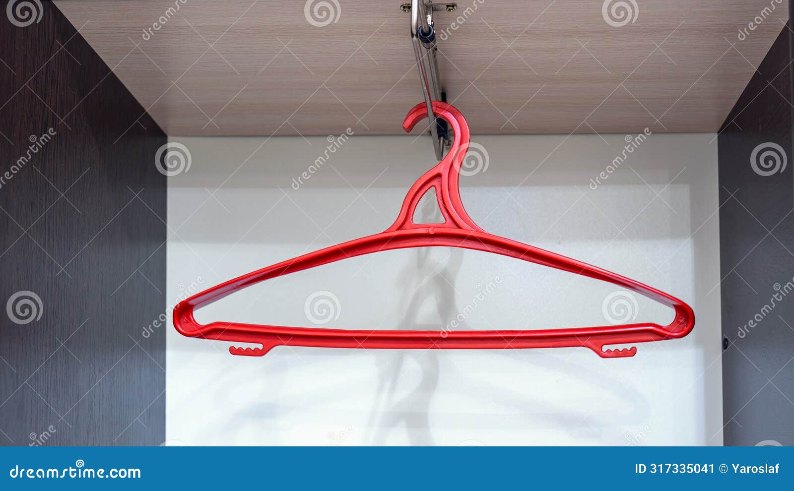 Red Plastic Hanger Hanging on Metal Rail Inside Modern Wardrobe ...