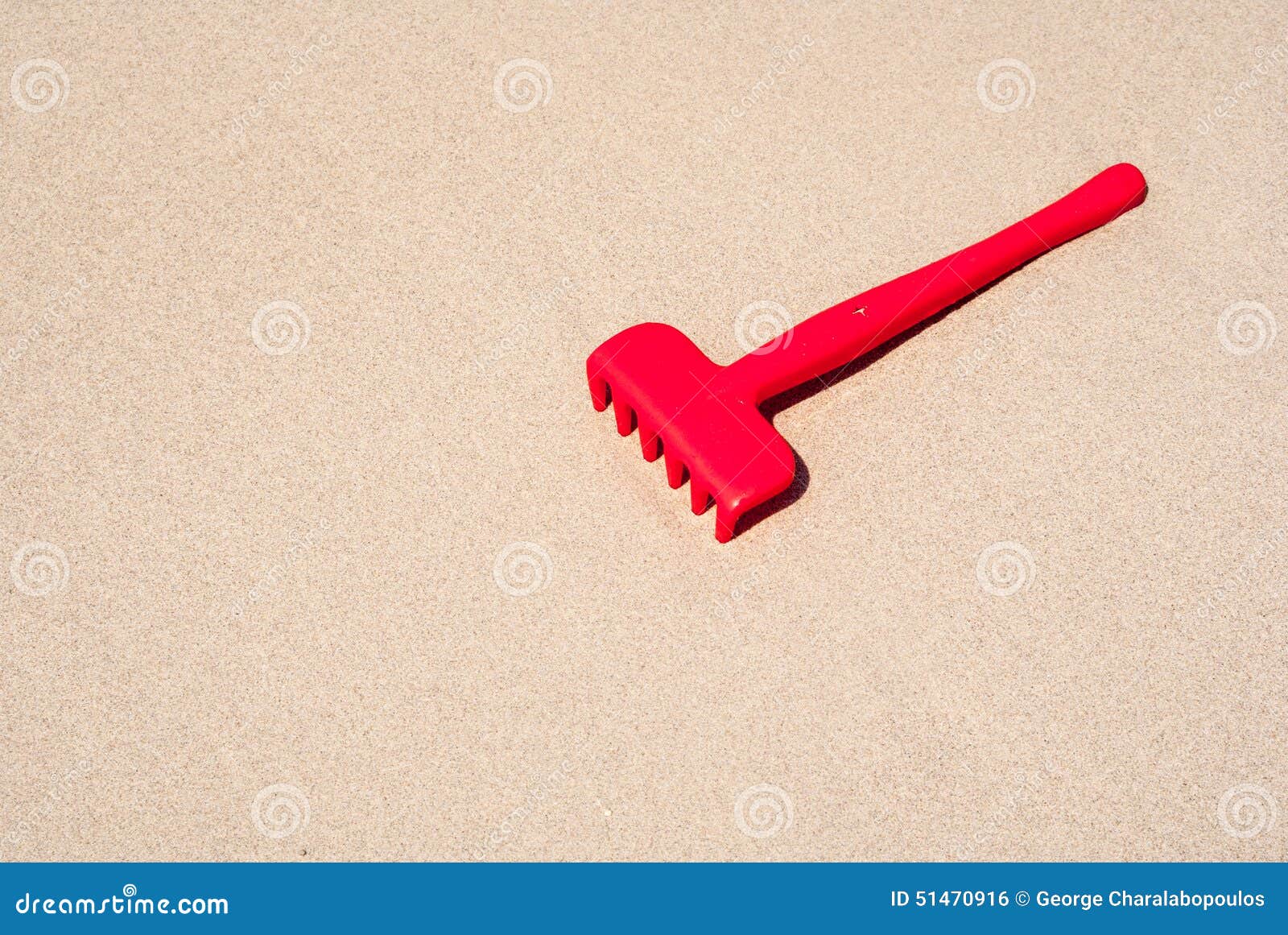 Red rake on the sand stock photo. Image of escape, beach - 51470916