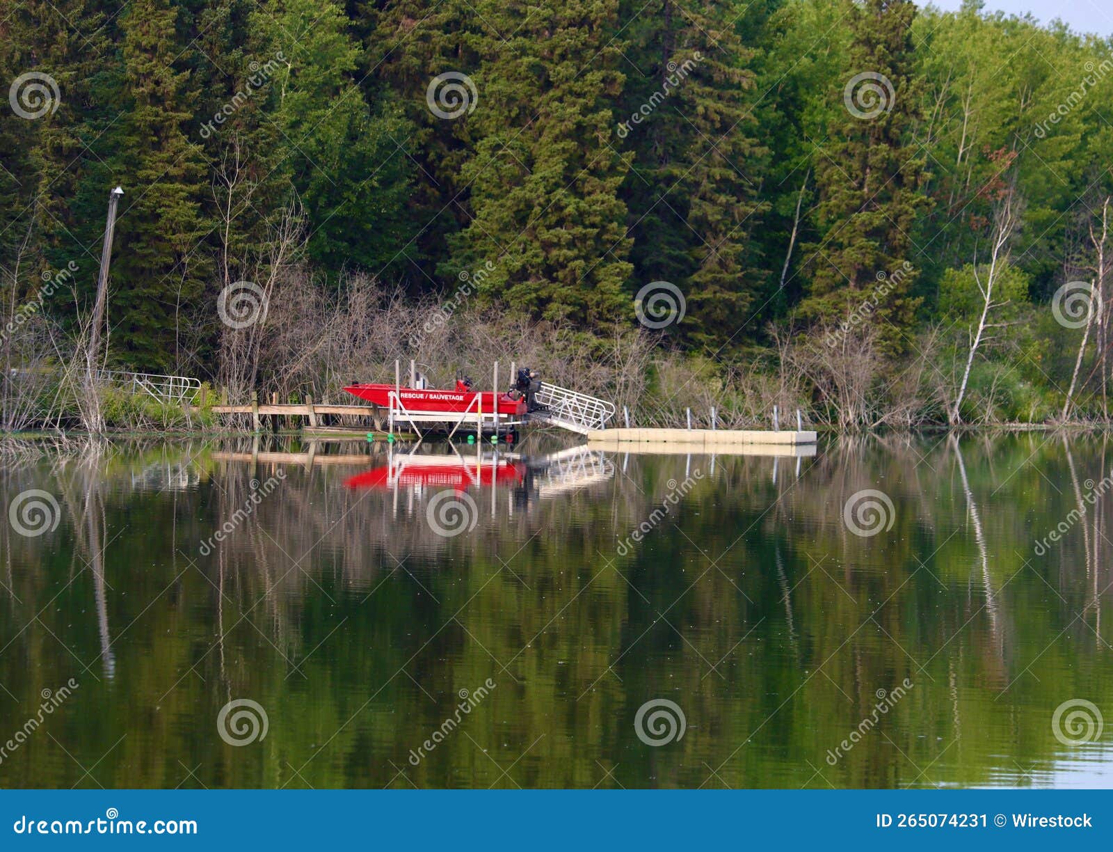 Red Rescue Boat with Trees Reflected in Water on a Summer Day Editorial ...