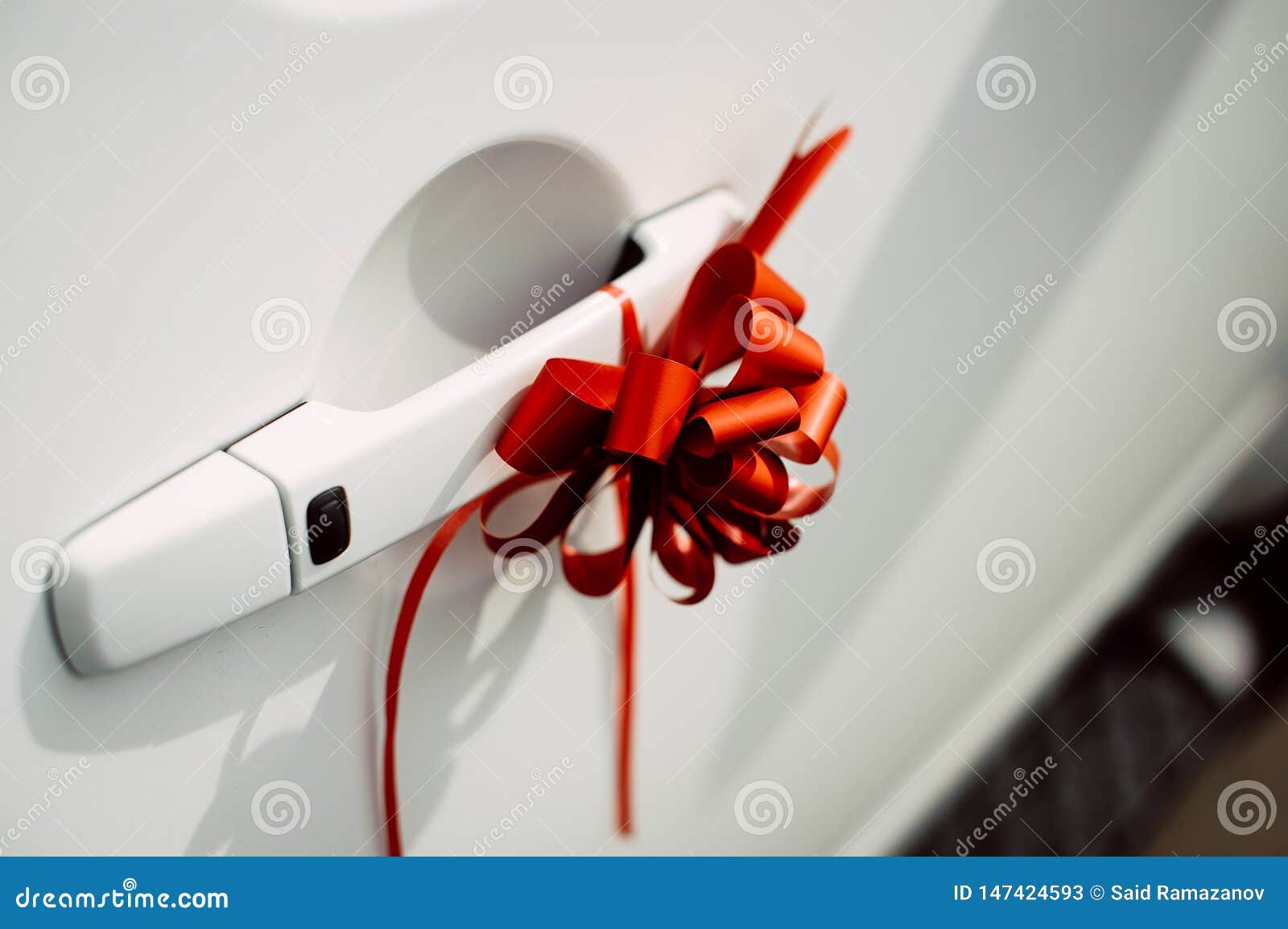 Red Ribbon Bow on the Door Handle of a White Car Stock Image - Image of ...