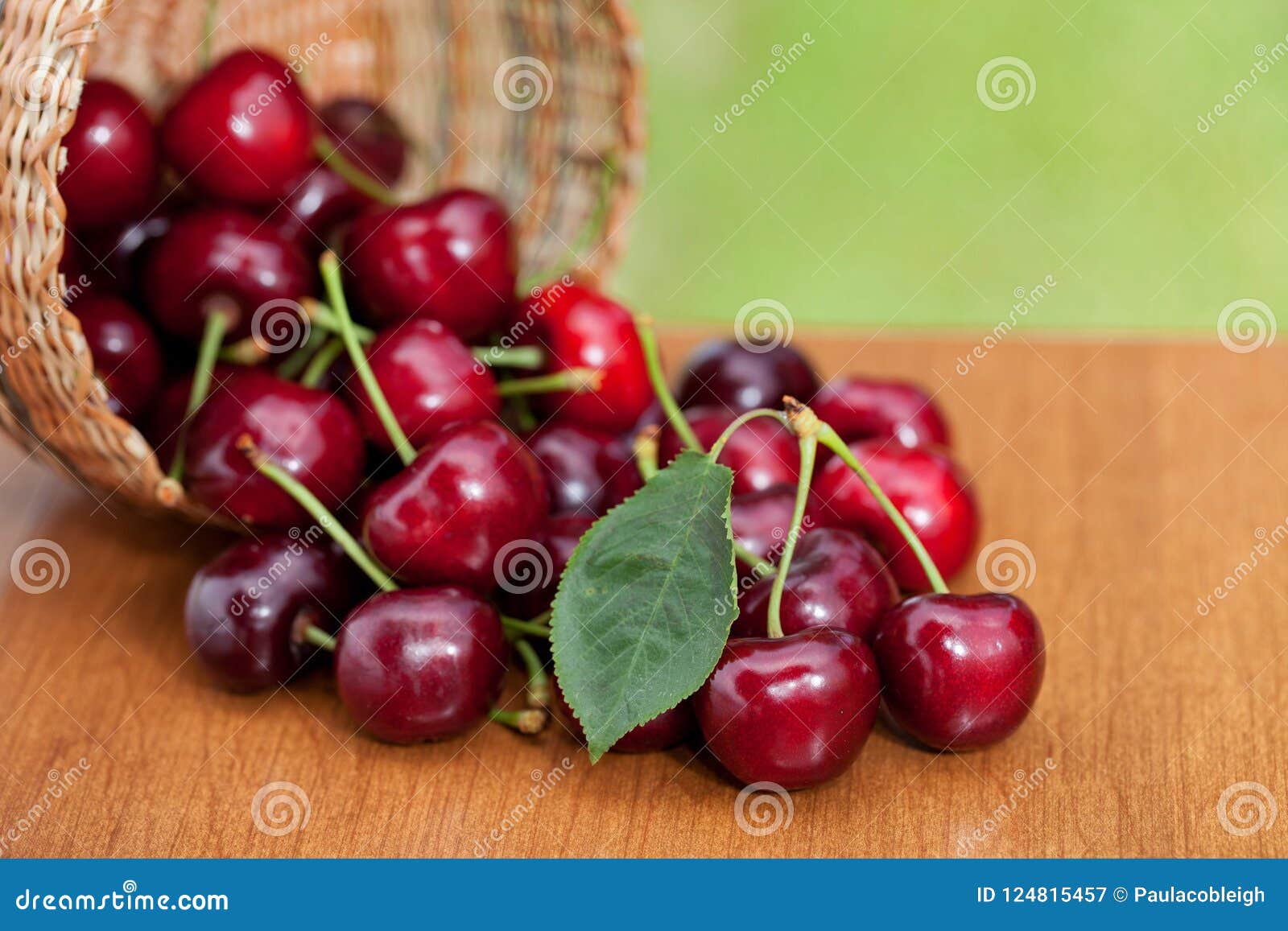 Red Ripe Cherries Spilling From Basket On A Wood Table Stock Image