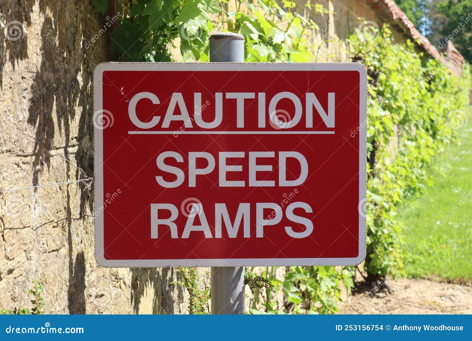 A Red Road Sign Warning of Speed Ramps Ahead by the Exit of a Public ...