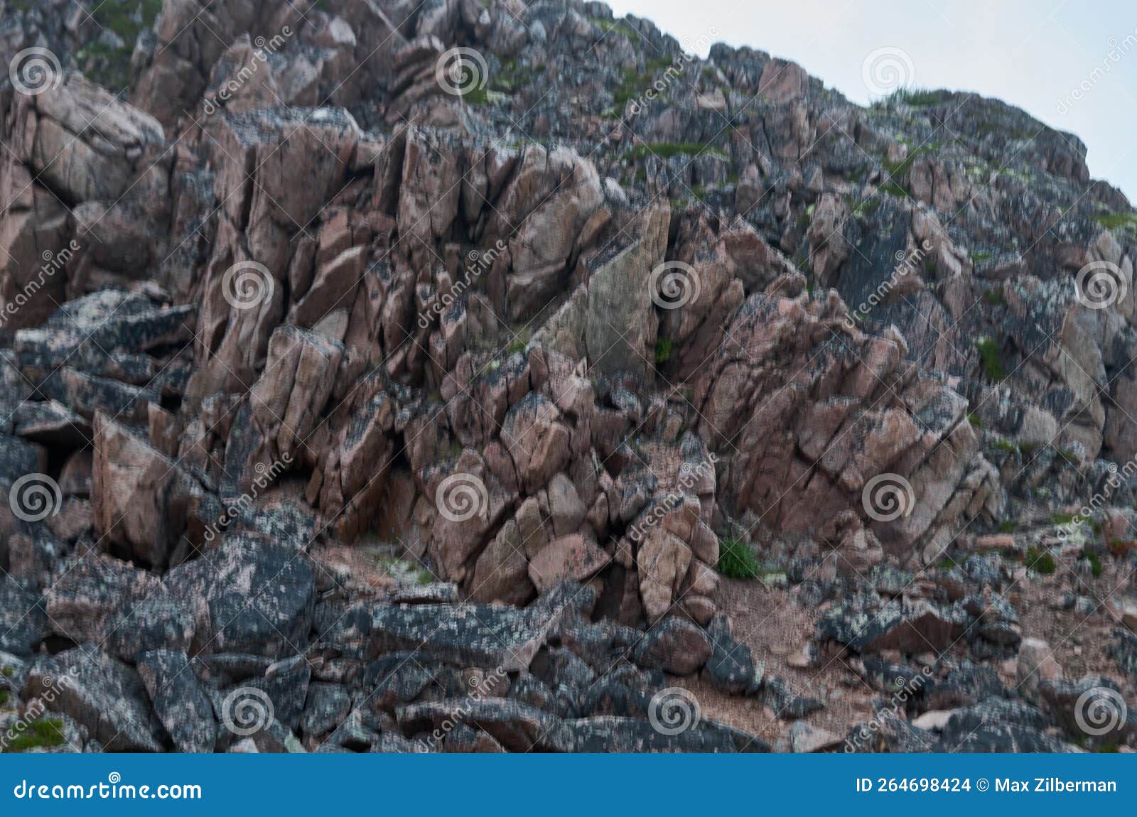 Red Rocky Slope of a Cliff Covered in Places with Moss and Grass Stock ...