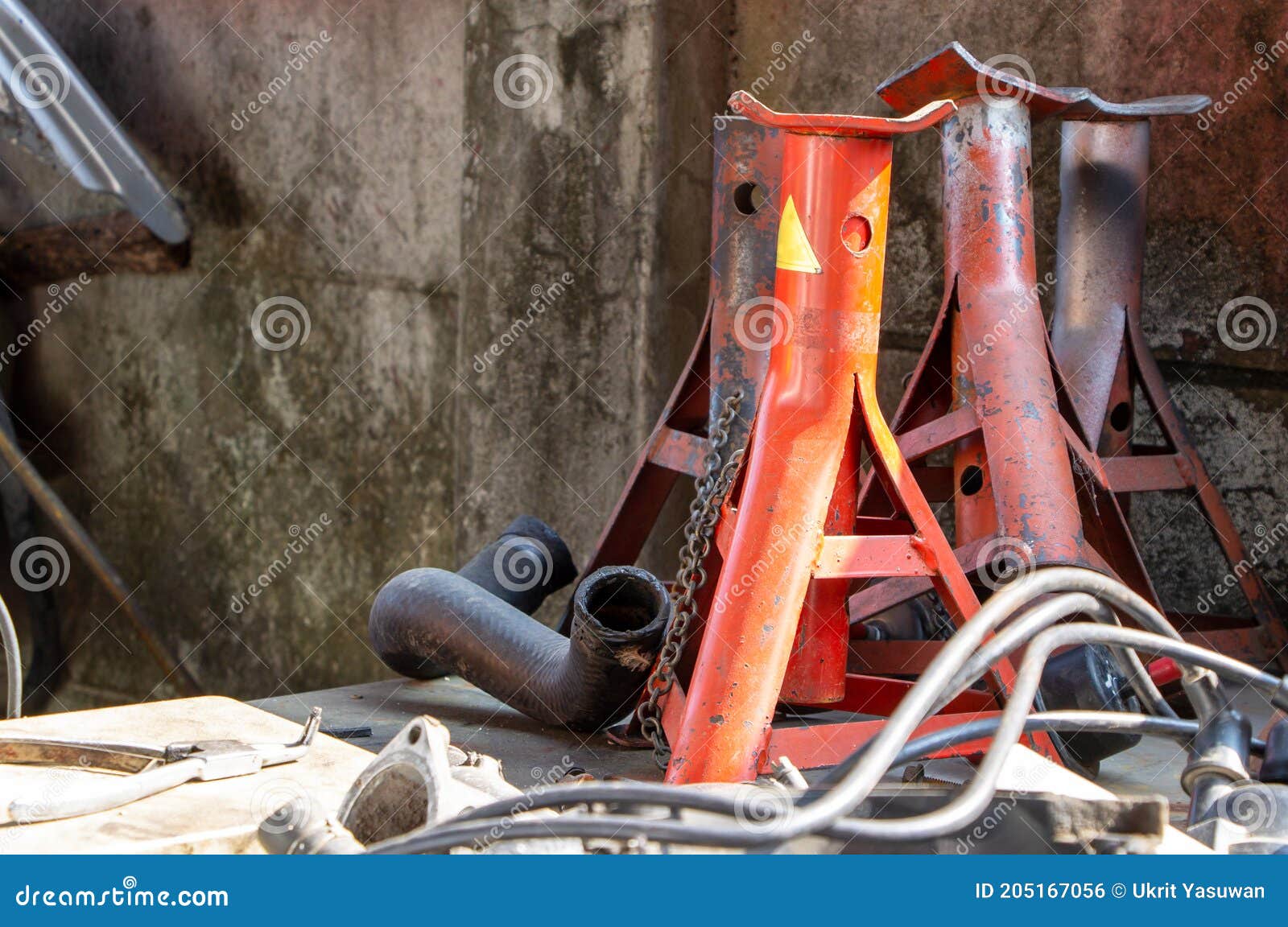 Red Rusty Jack Stand on a Table with Another Used Engine Part in a ...
