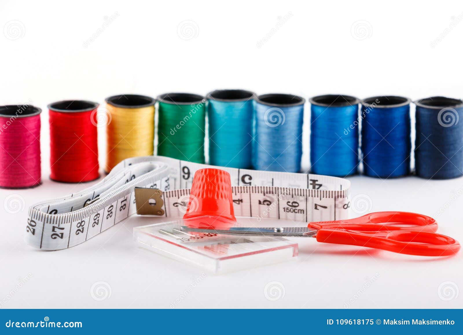 Red Scissors, Measuring Tape and Thimble with Spools of Thread on White ...