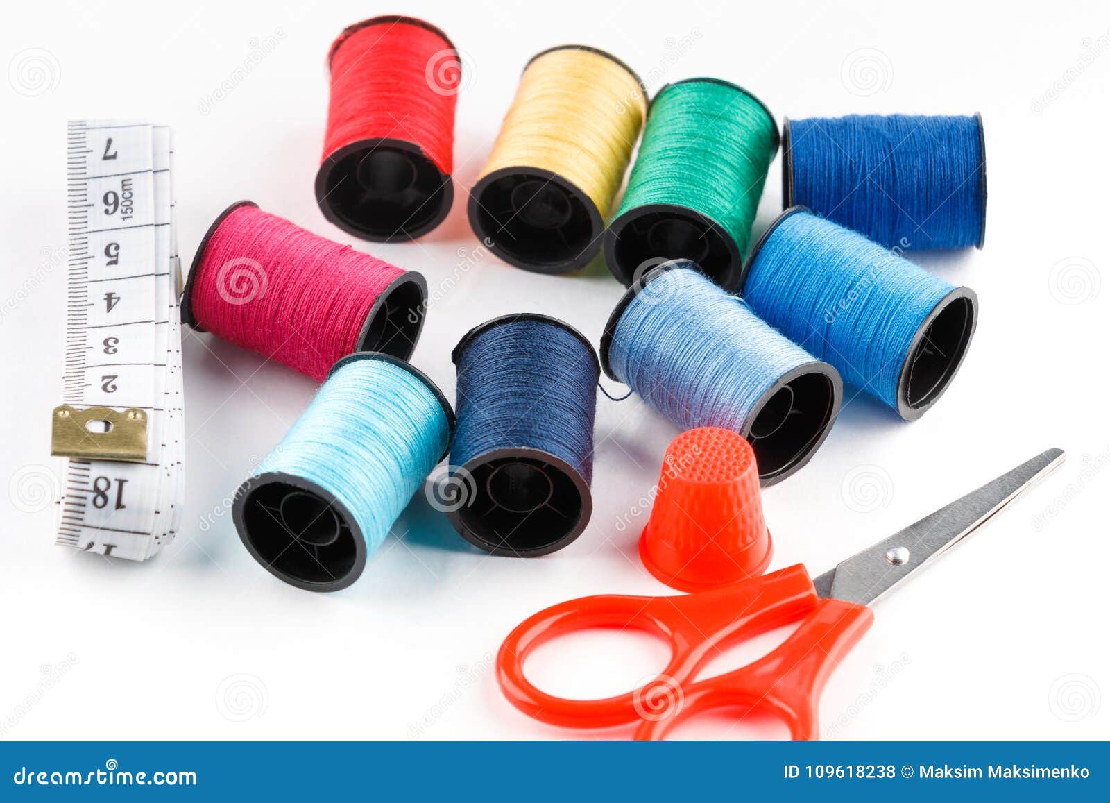 Red Scissors, Measuring Tape and Thimble with Spools of Thread on White ...