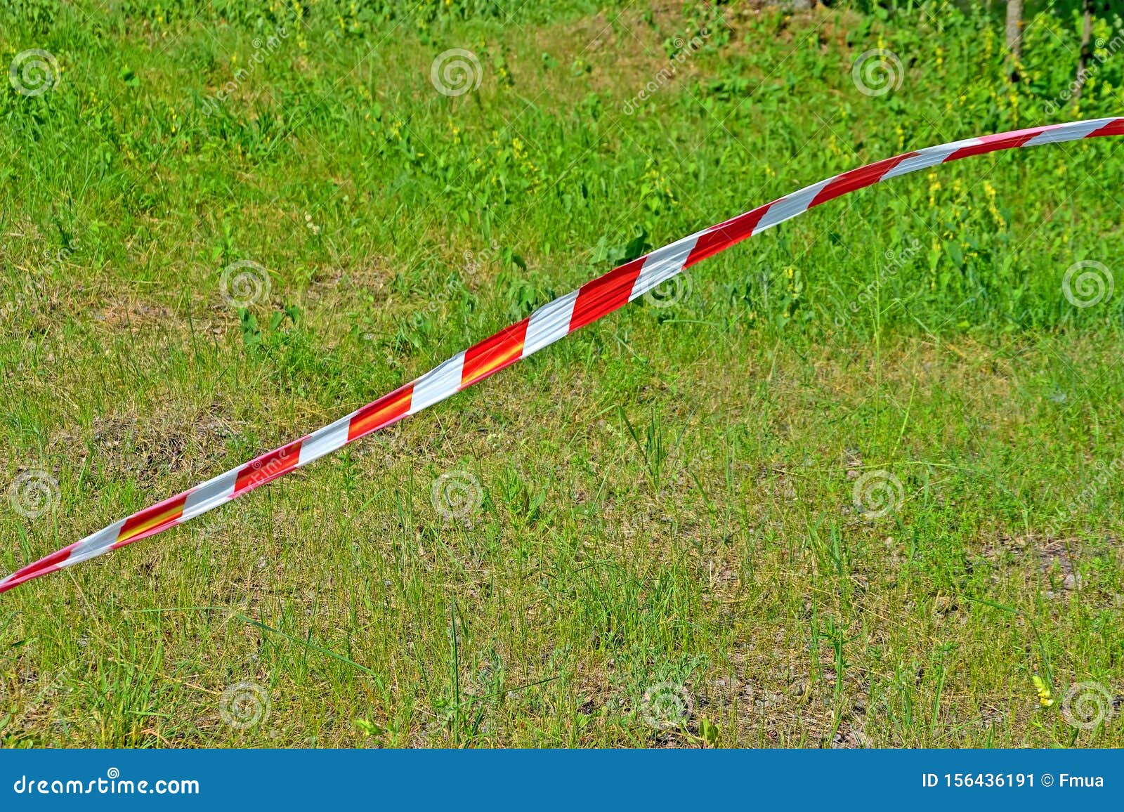 Red Security Warning Ribbon on Green Grass, Windy Environment, Stock ...
