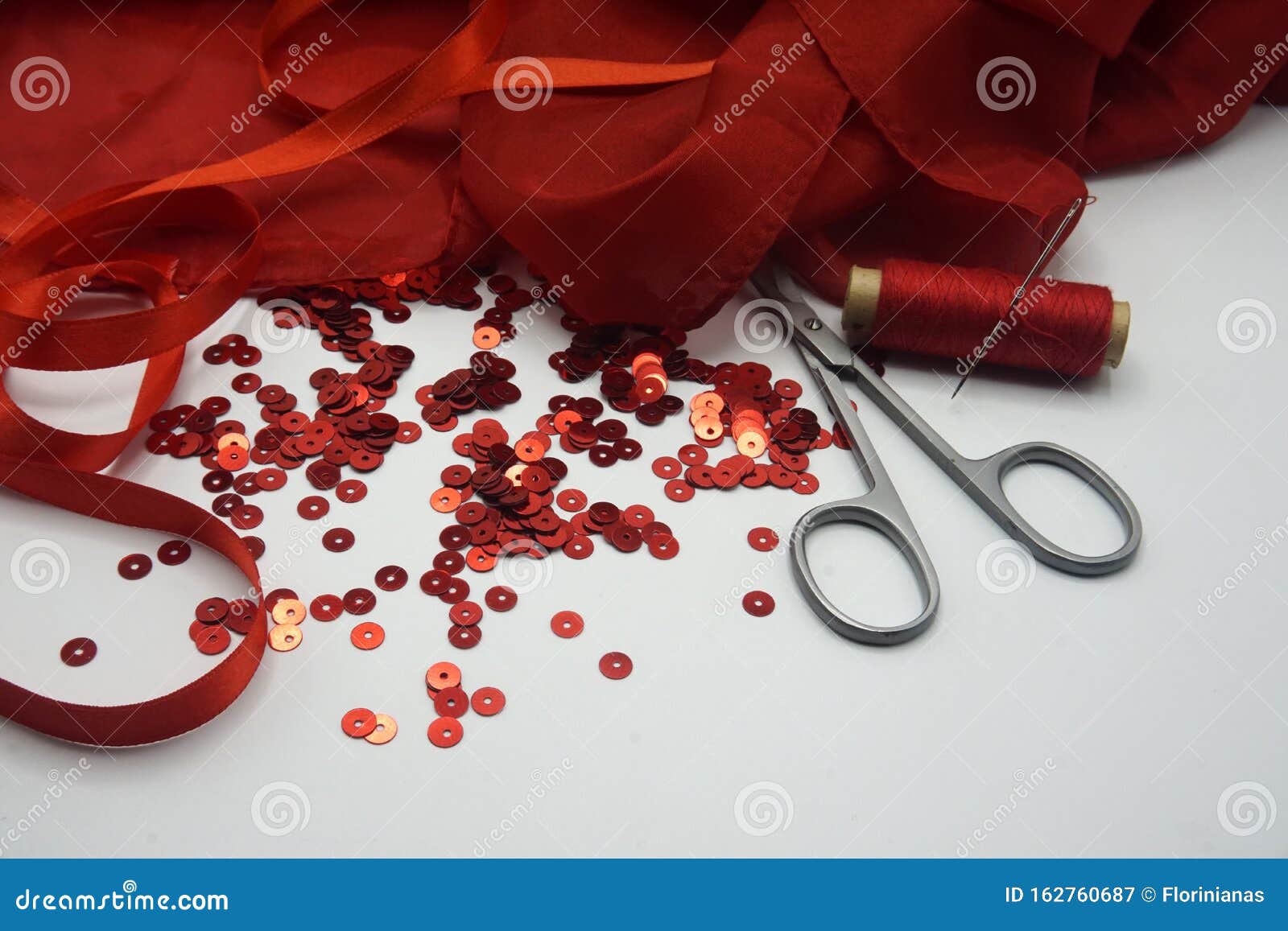 Red Sequins, Spool of Red Thread,needle and Scissors on Rippled Red ...