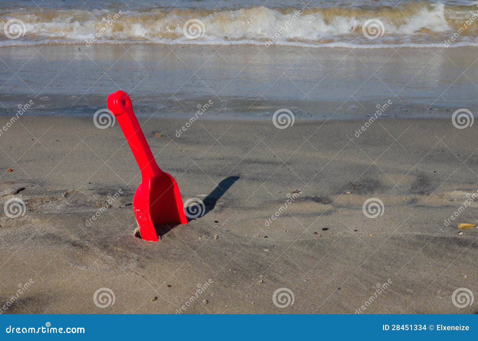 Red shovel at the beach stock photo. Image of holidays - 28451334