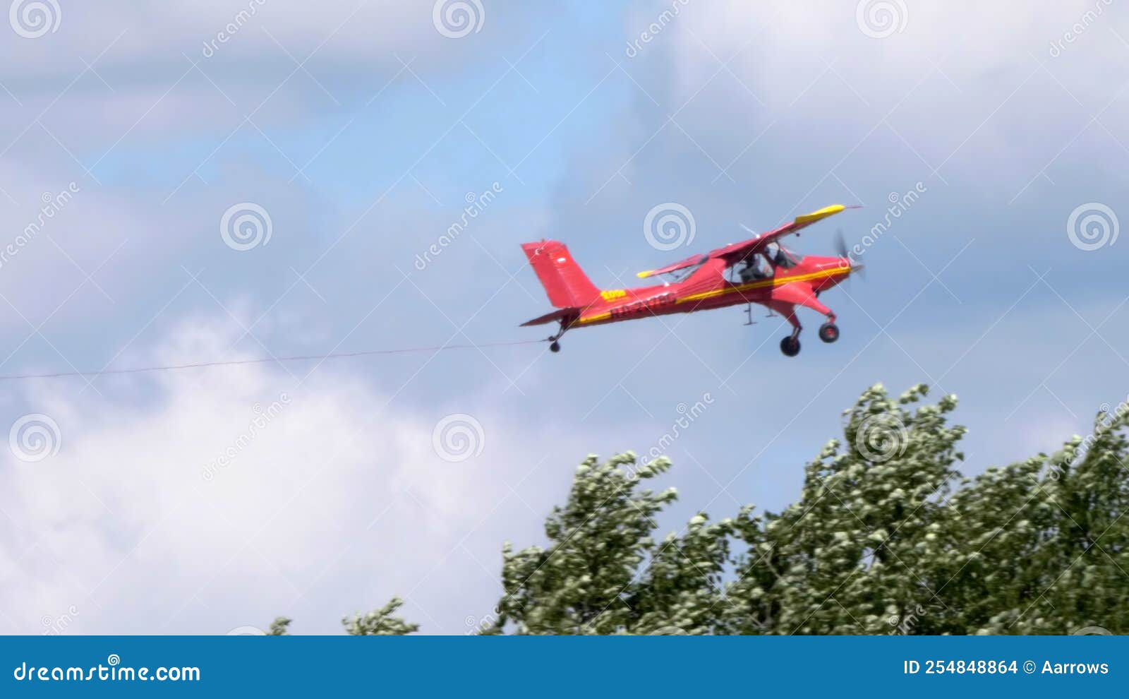 Red Small Sport Plane Flying in the Sky Pulls on a Rope the Glider ...