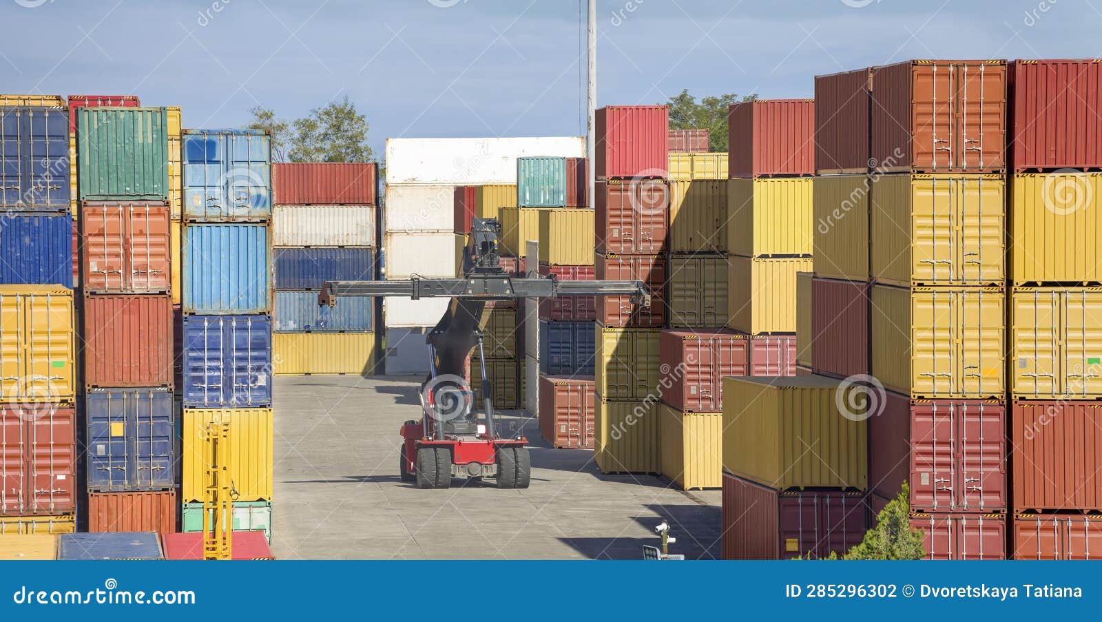 A Red Stacker Drives Along the Rows of Shipping Containers at the Port ...
