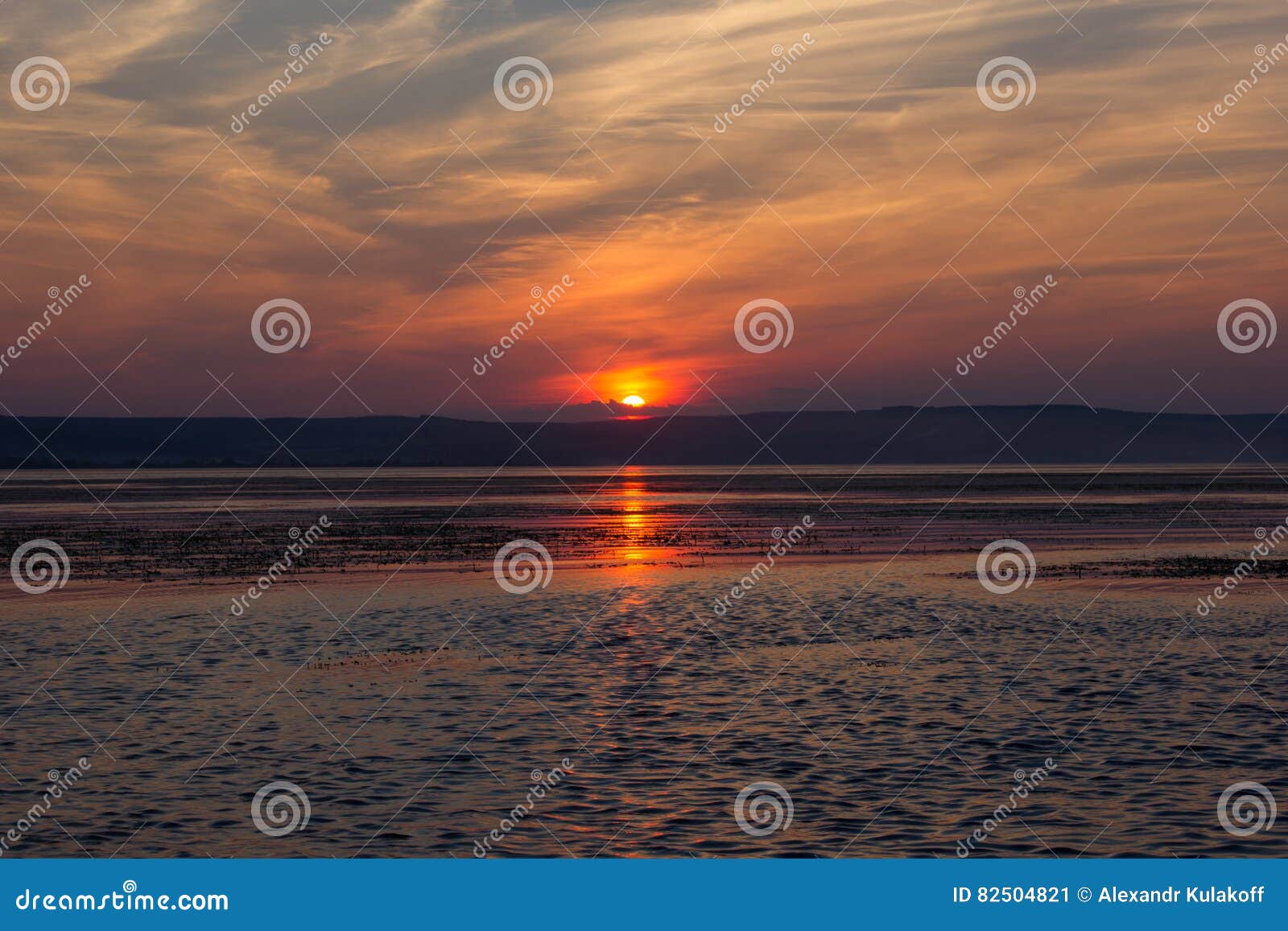 Red Sunset Over the Water. Dramatic Red Sunset. Sun Hiding Behind the ...