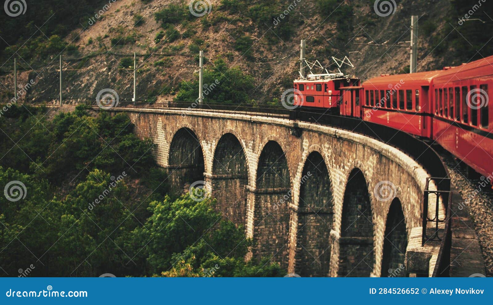 Red Train Moves Along Picturesque Bridge Stock Photo - Image of trees ...