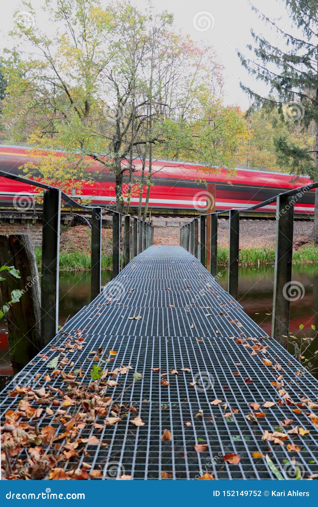 Red Train Quickly Passing a Lake with a Bridge in Germany Stock Photo ...