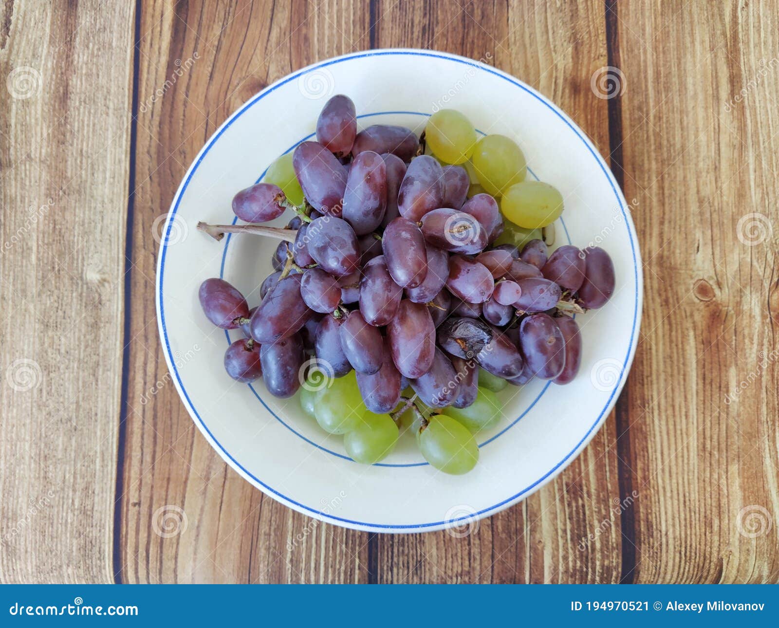 Red and White Grapes on a Plate on a Wooden Table Background Stock ...