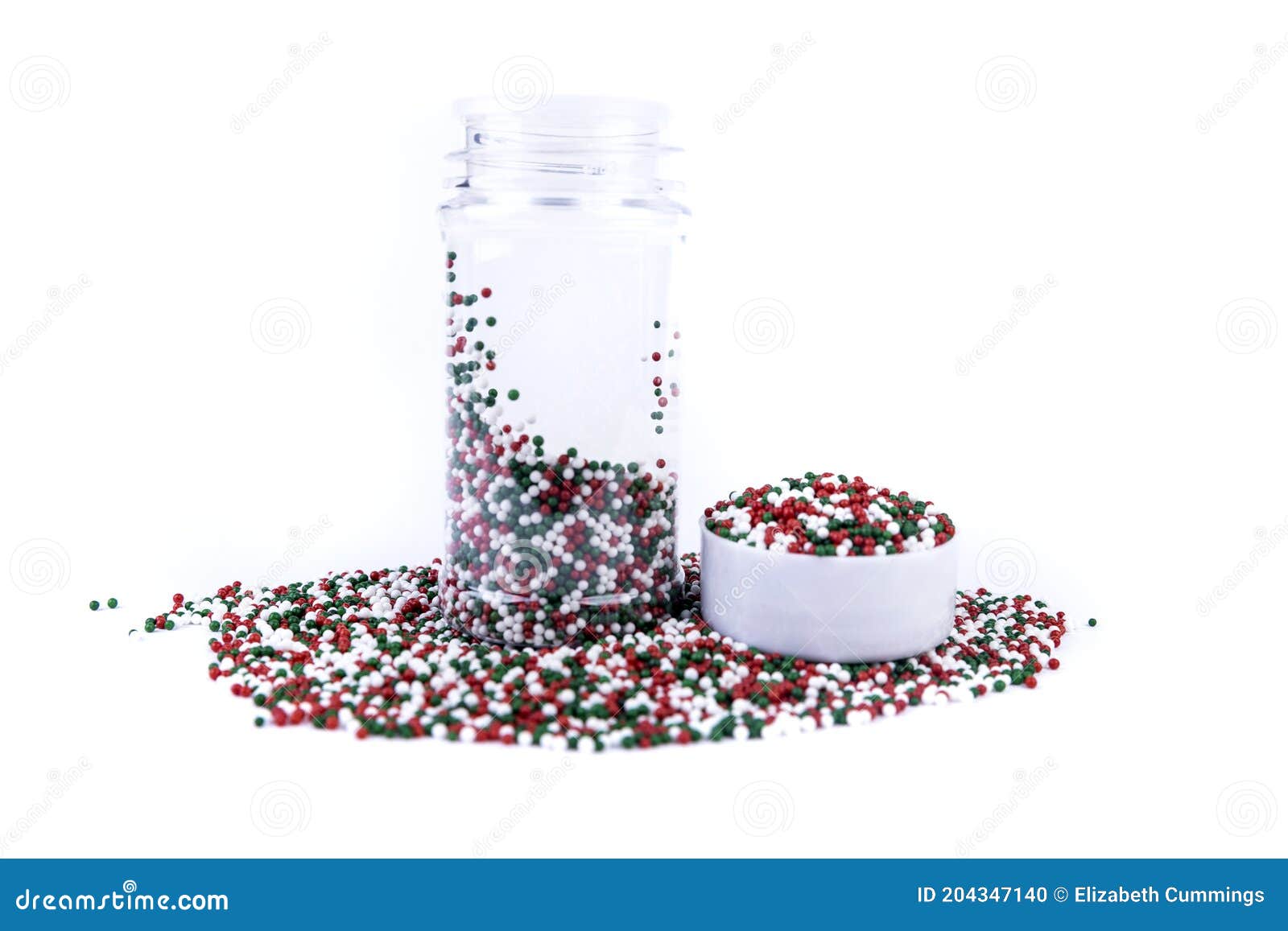 Red White and Green Sprinkles in a Container and Lid in a Pool of Tasty ...