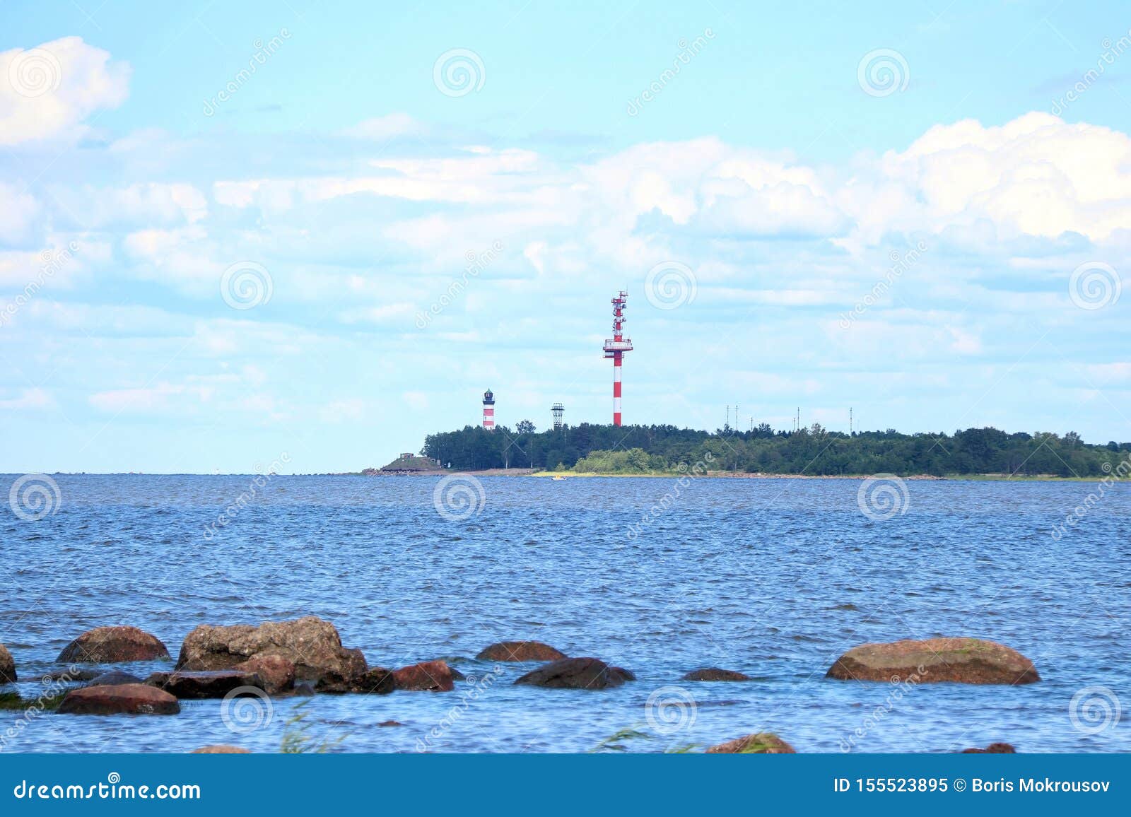 Red-and-white Lighthouse on the Beach Rocks in the Water in the ...