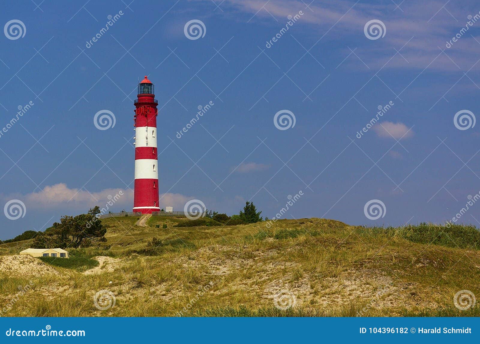 Red and White Lighthouse on a Sand Dune Lightly Covered with Beach ...