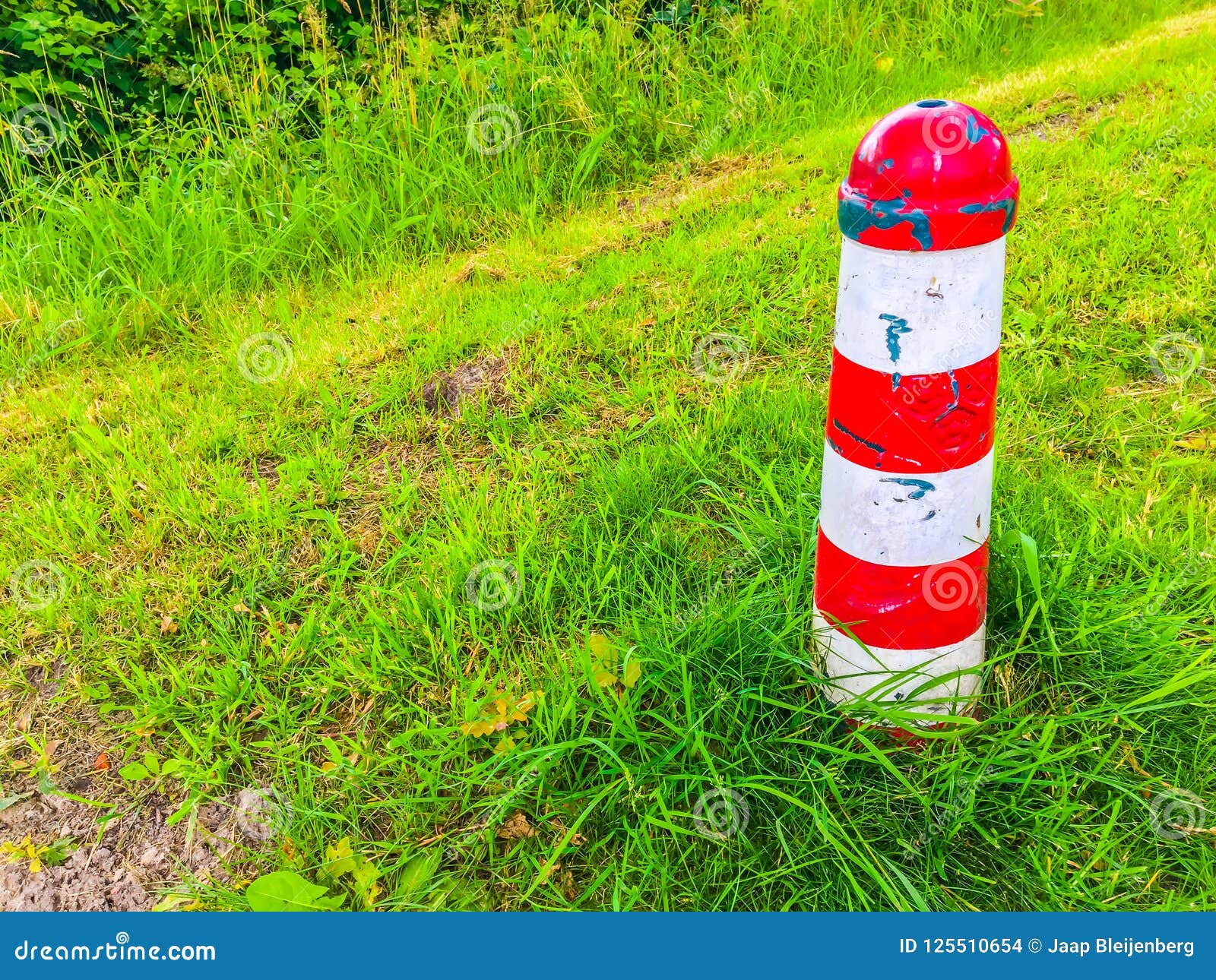 Red and White Striped Landmark Pole in a Grass Landscape Stock Photo ...