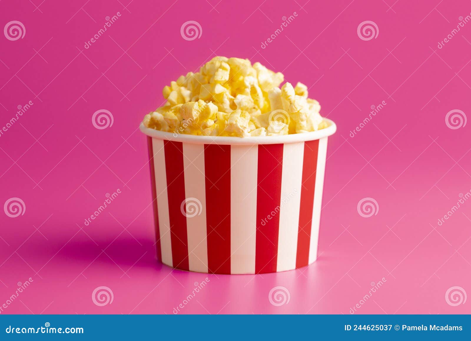 Red and White Striped Popcorn Bucket on a Bright Pink Background Stock ...
