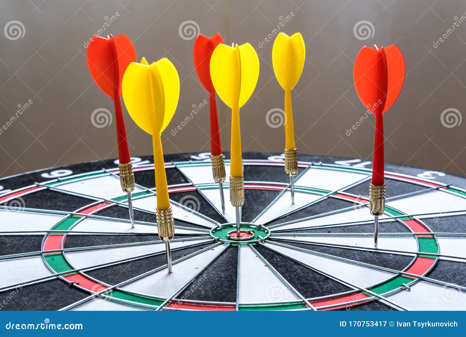 Red And Yellow Dart Arrows Hitting In The Target Center Of Dartboard