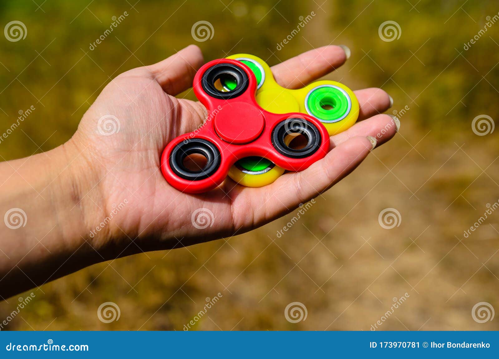 Red and Yellow Fidget Spinners in Female Hand Stock Image - Image of ...