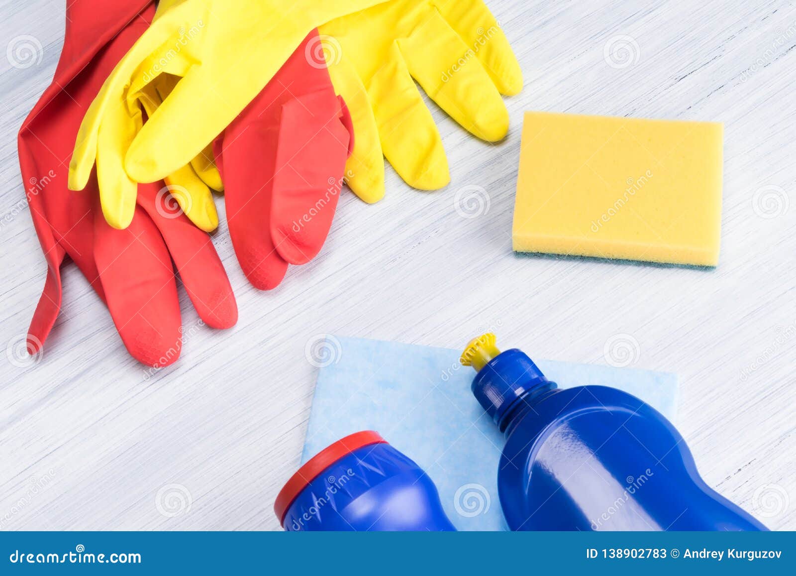 Red and Yellow Rubber Gloves and Cleaning Agents on a Light Gray Table ...