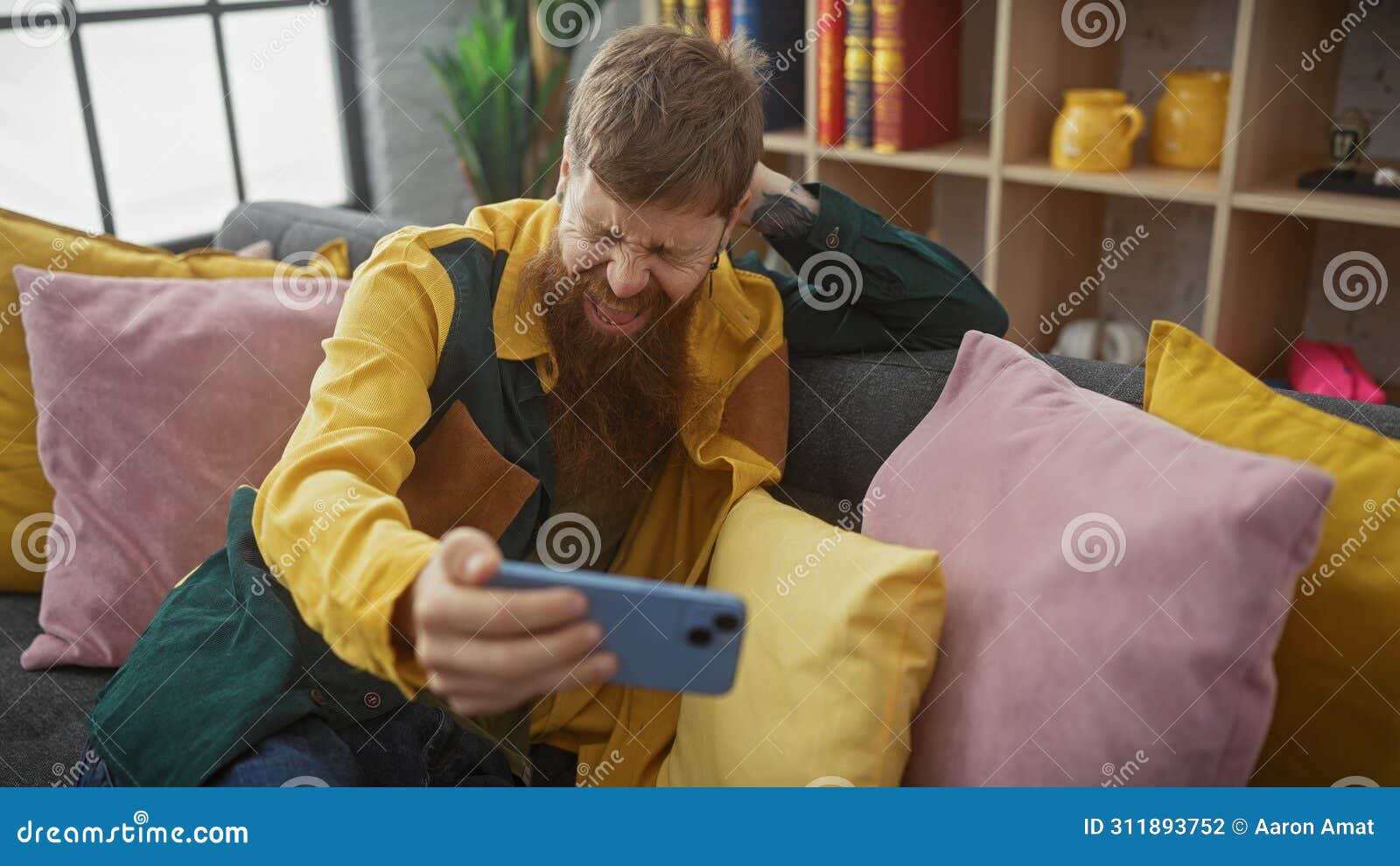 Redhead Beard Man In Colorful Interior Laughing While Looking At