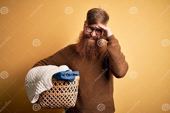 Redhead Irish Man With Beard Doing Housework Laundry Over Yellow