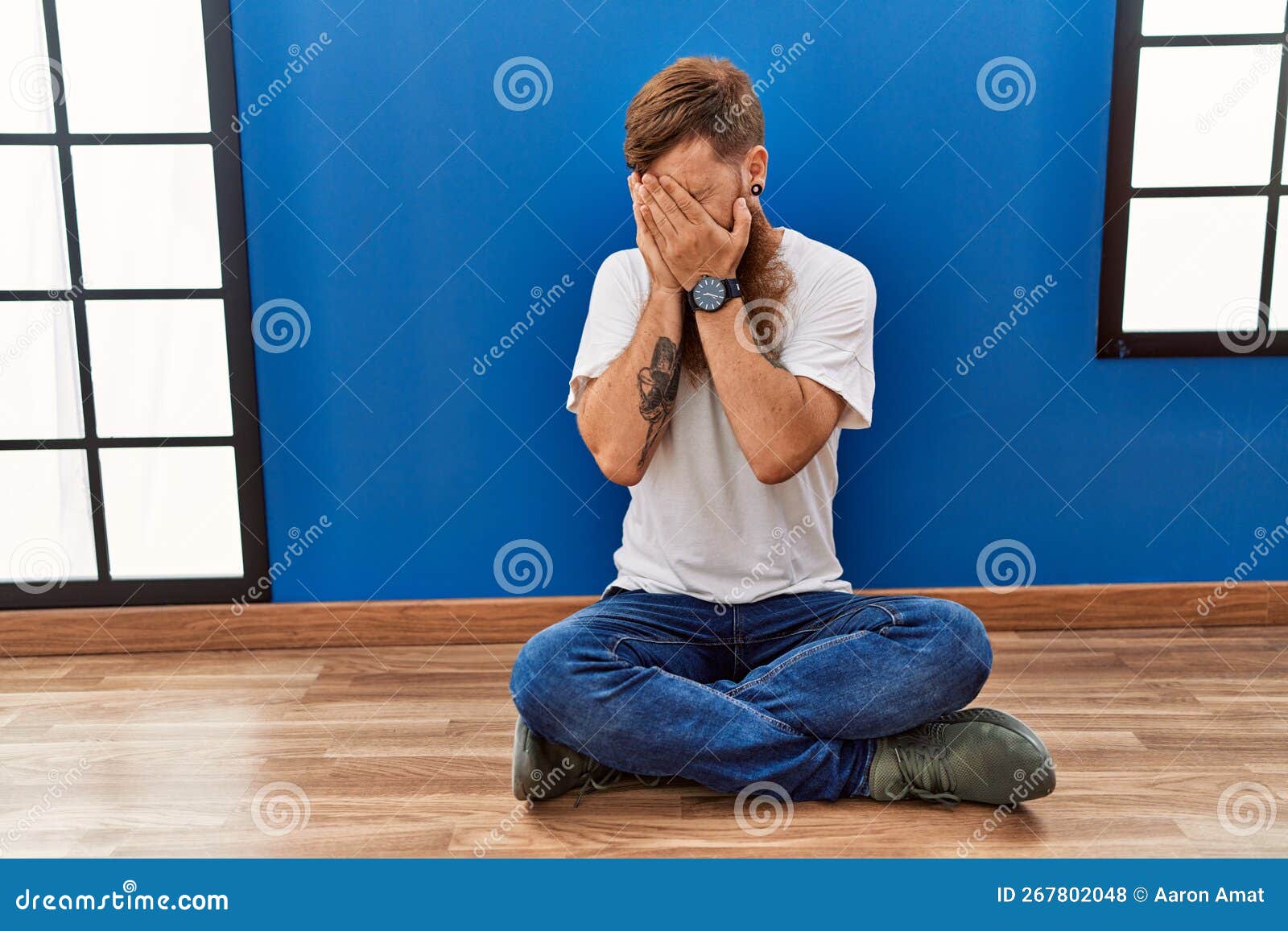 Redhead Man with Long Beard Sitting on the Floor at Empty Room with Sad ...