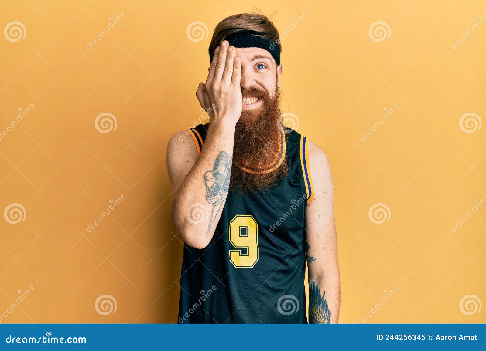 Redhead Man With Long Beard Wearing Basketball Uniform Covering One Eye