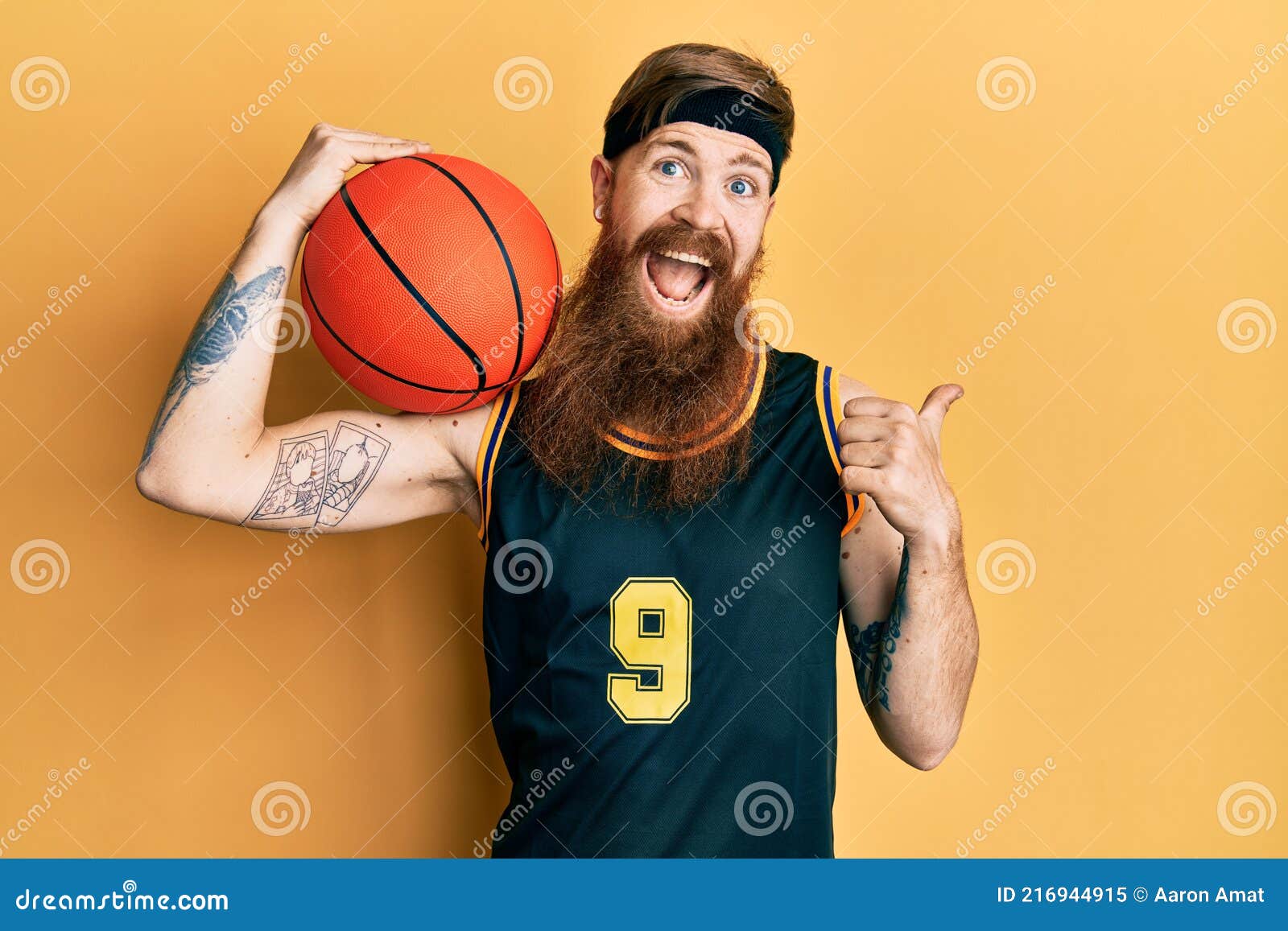 Redhead Man With Long Beard Wearing Basketball Uniform Holding Ball