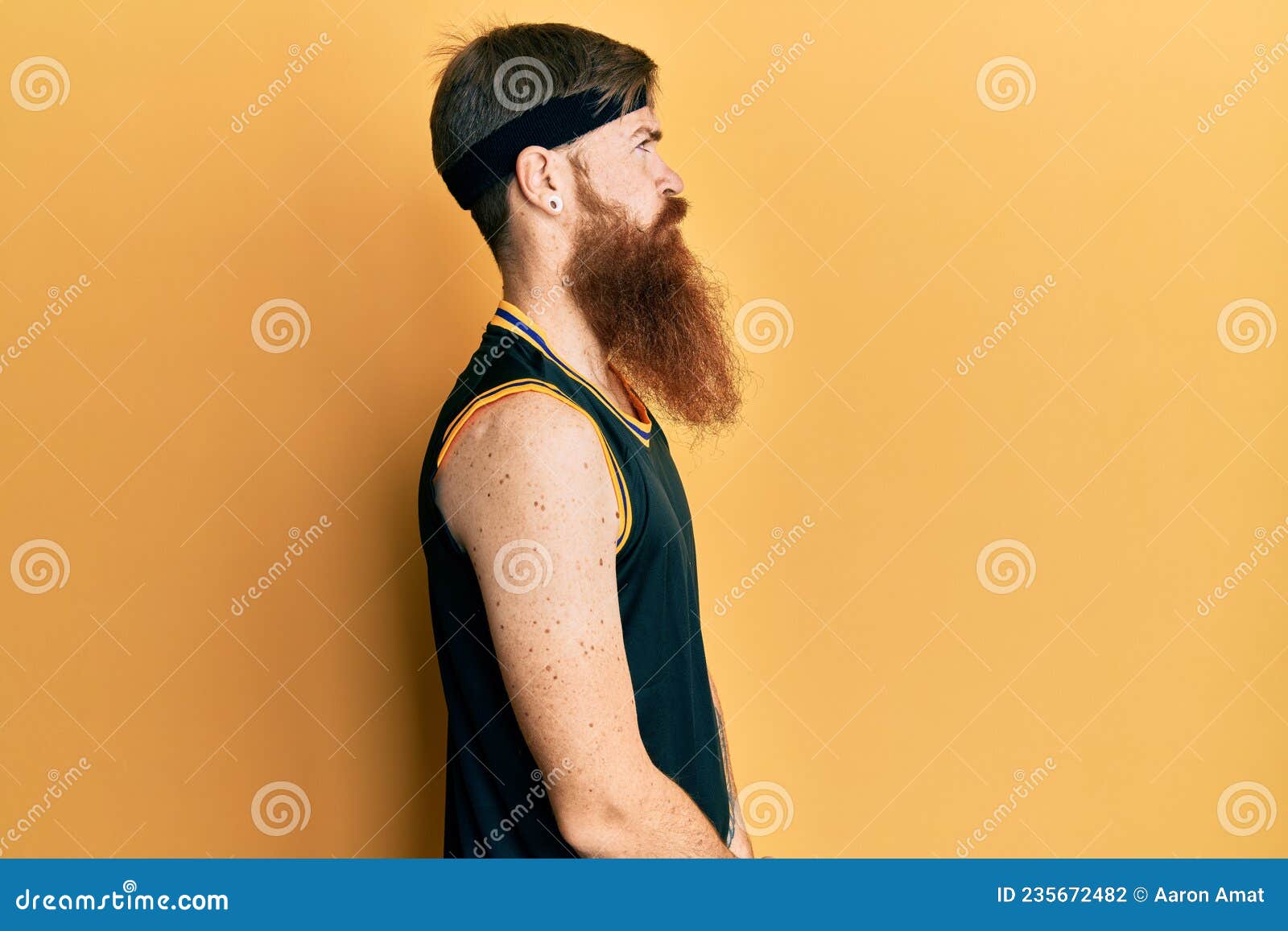 Redhead Man With Long Beard Wearing Basketball Uniform Looking To Side