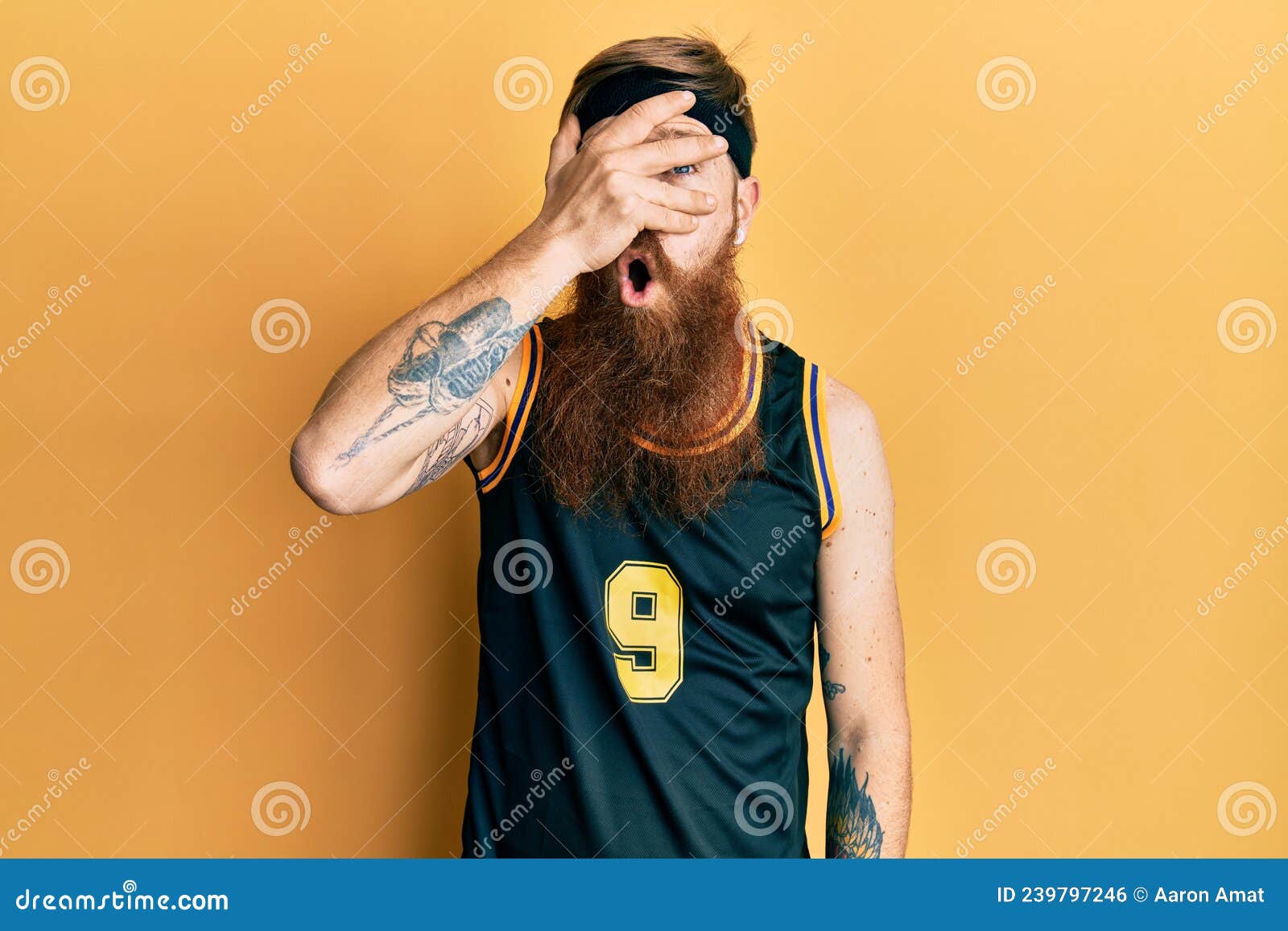 Redhead Man With Long Beard Wearing Basketball Uniform Peeking In Shock