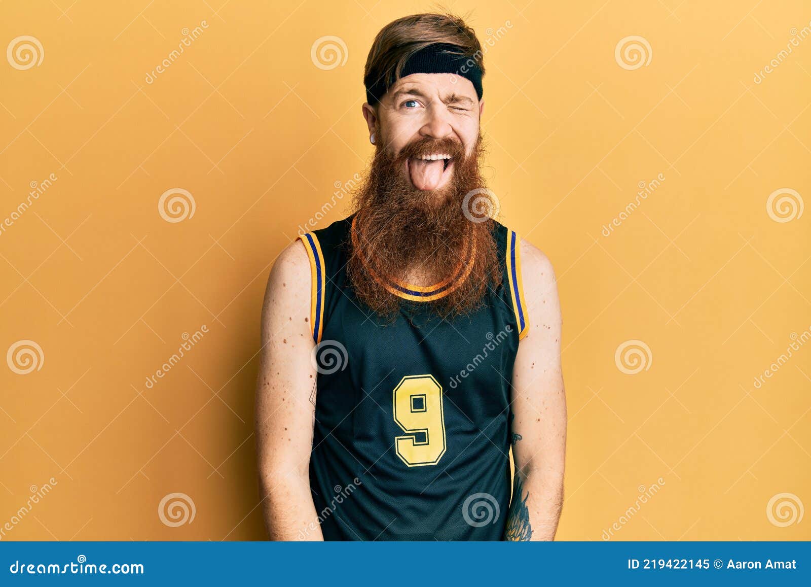 Redhead Man With Long Beard Wearing Basketball Uniform Winking Looking