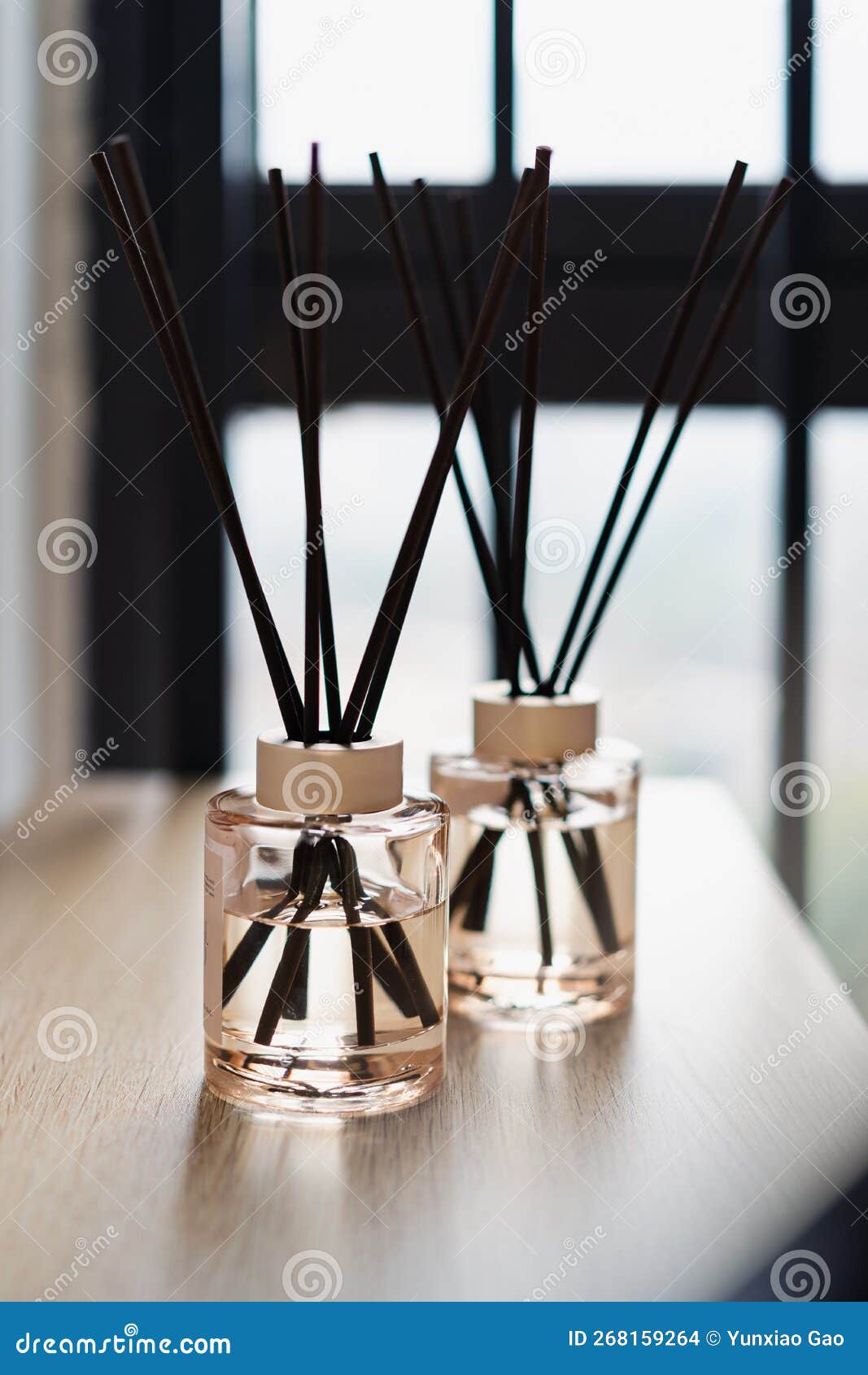 Reed Diffuser in Glass Bottle Placed on Wood Table Against Window on ...