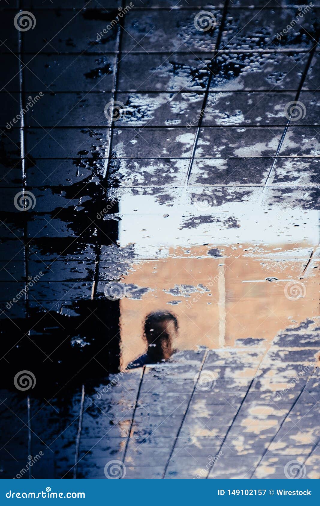Reflection of an Asian Person`s Face in the Pool of Water on the Ground ...