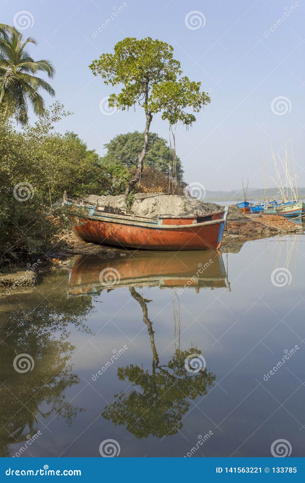 Reflection of a Big Red Boat and a Green Tree in the River Against the ...