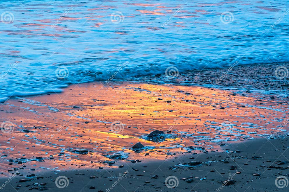 Reflection of the Light of the Setting Sun in the Water on the Beach ...