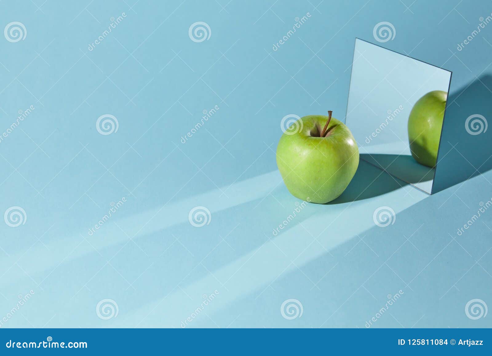 The Apple is Green, a Square Mirror on a Blue Background, a Reflection ...