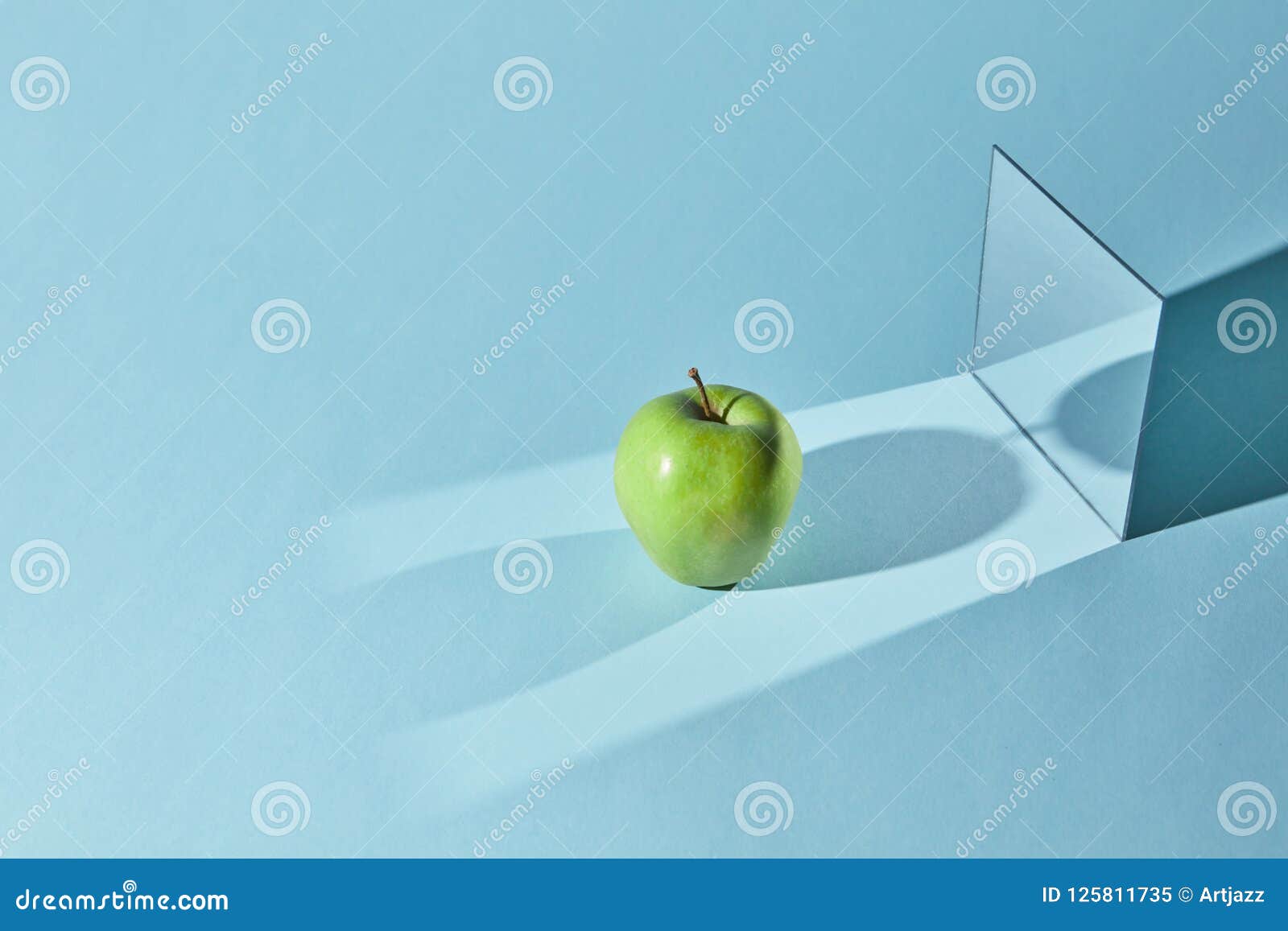 The Apple is Green, a Square Mirror on a Blue Background, a Reflection ...