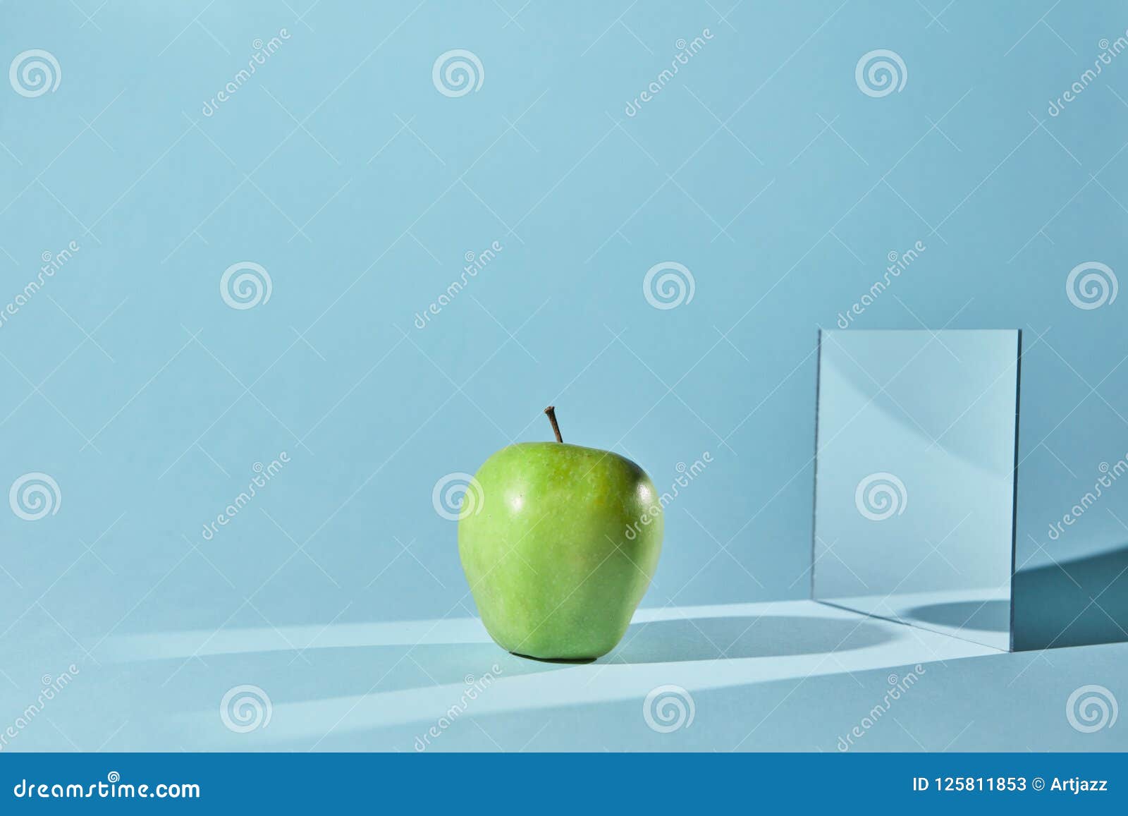 The Apple is Green, a Square Mirror on a Blue Background, a Reflection ...
