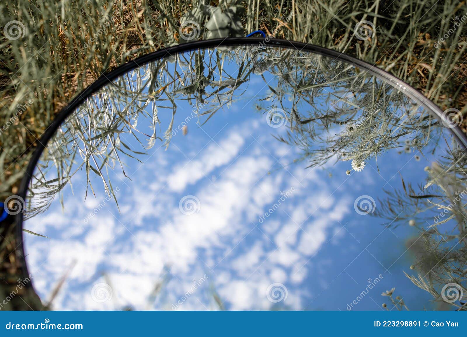 Mirror Reflecting the Blue Sky with Clouds Lying on the Green Grass ...