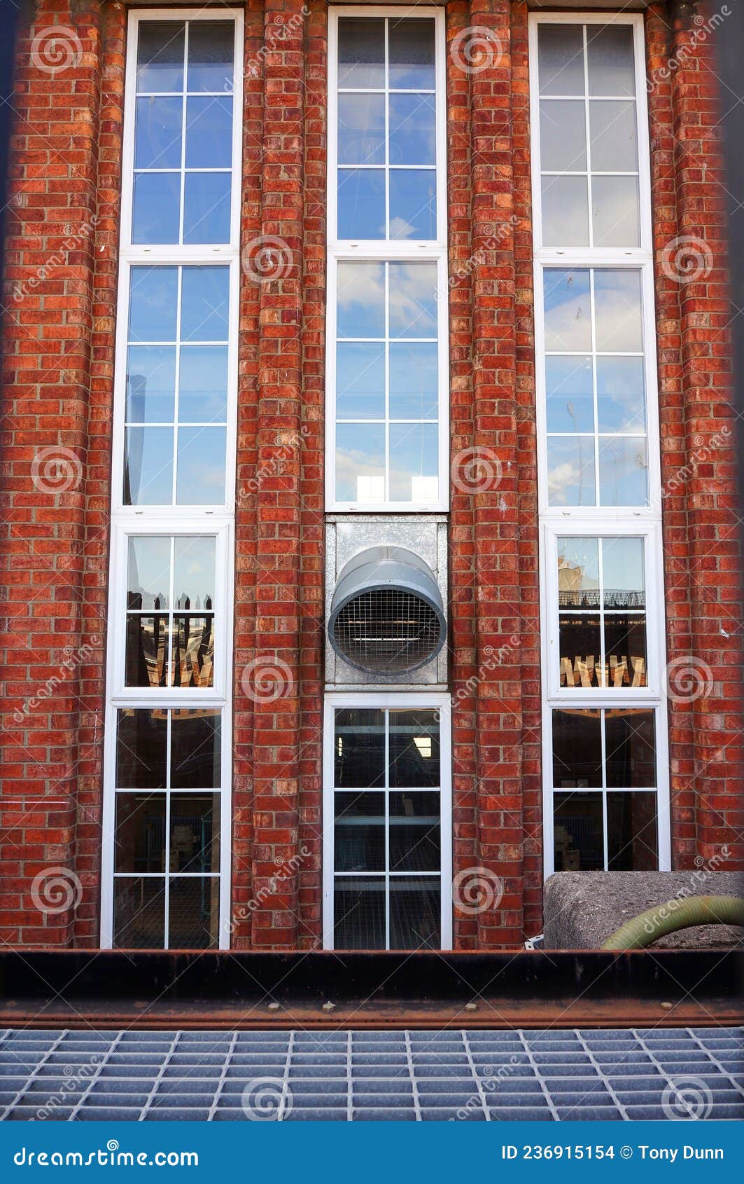 Reflections in the Tall Windows of a Red Brick Industrial Building ...