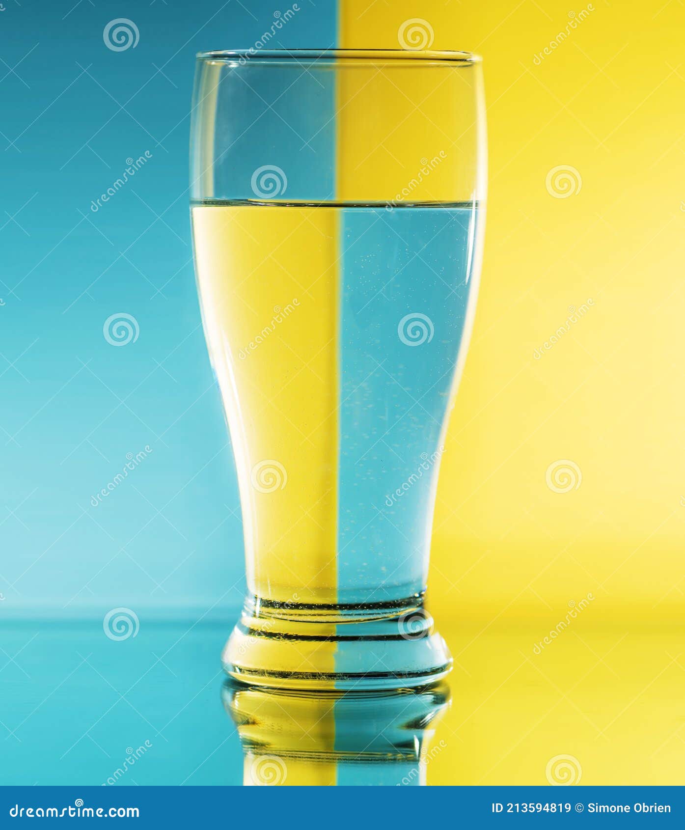 Refraction of Light by a Glass on a Blue and Yellow Squared Background ...