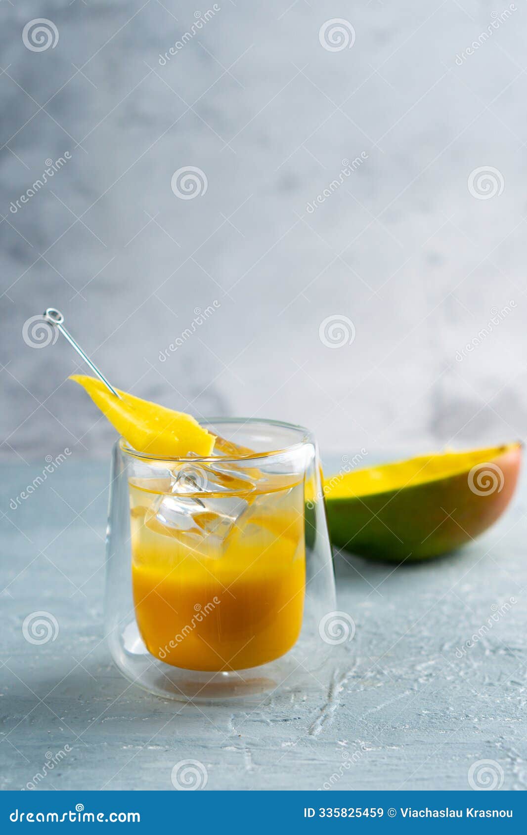 A Refreshing Glass of Mango Juice with Ice Cubes and a Spoon Inside it ...